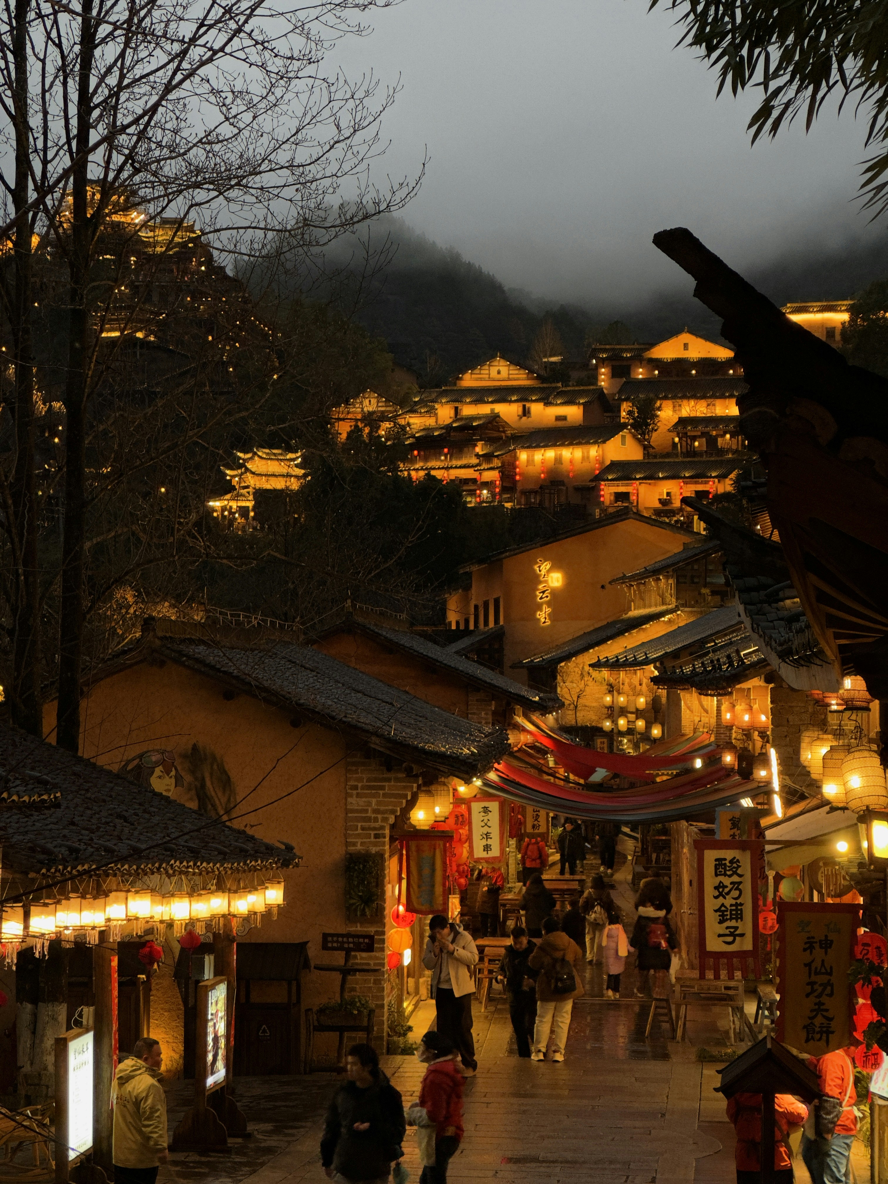 Lantern-lit village stairway into the mist