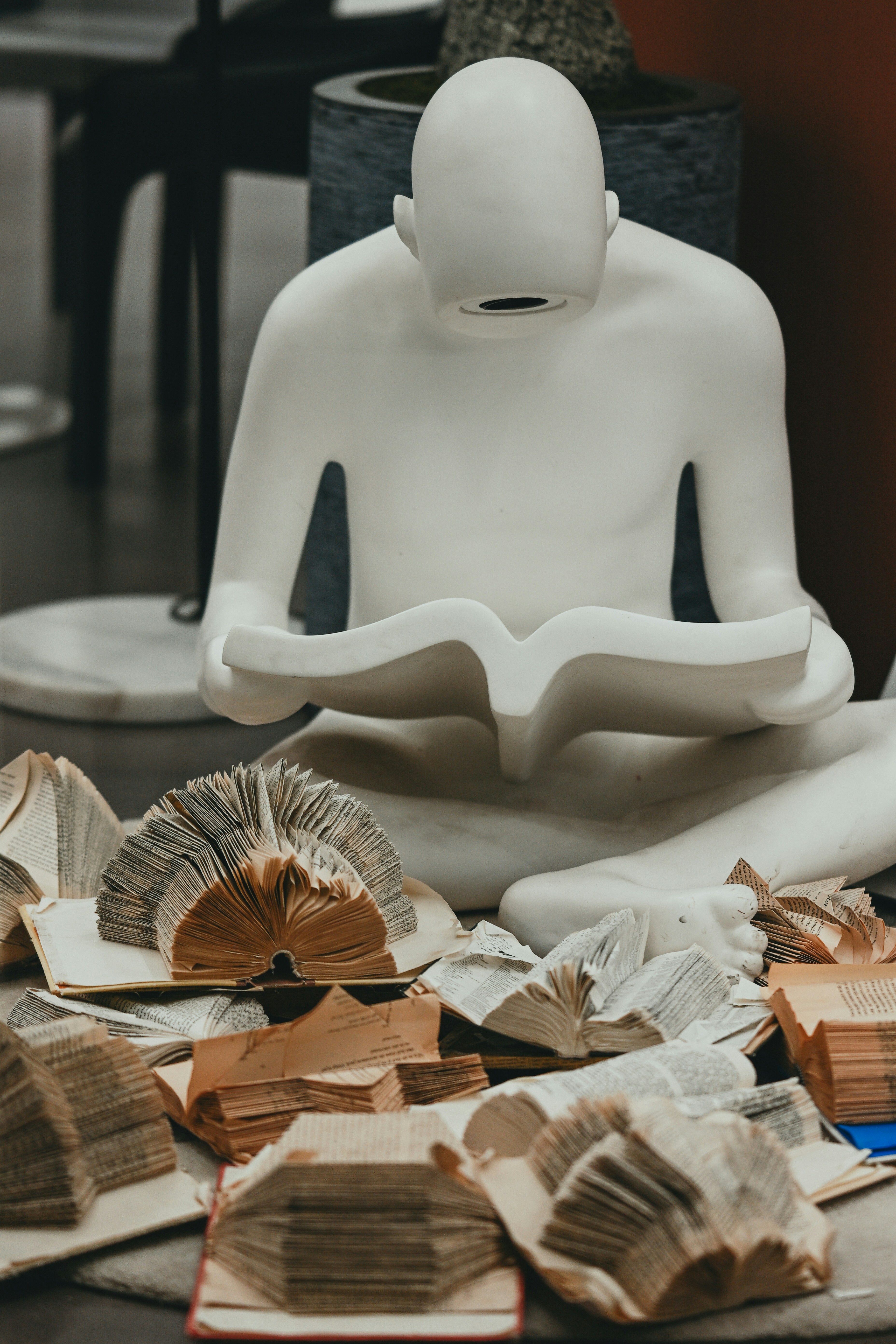 The Silent Reader: A White Statue among Crumpled Pages