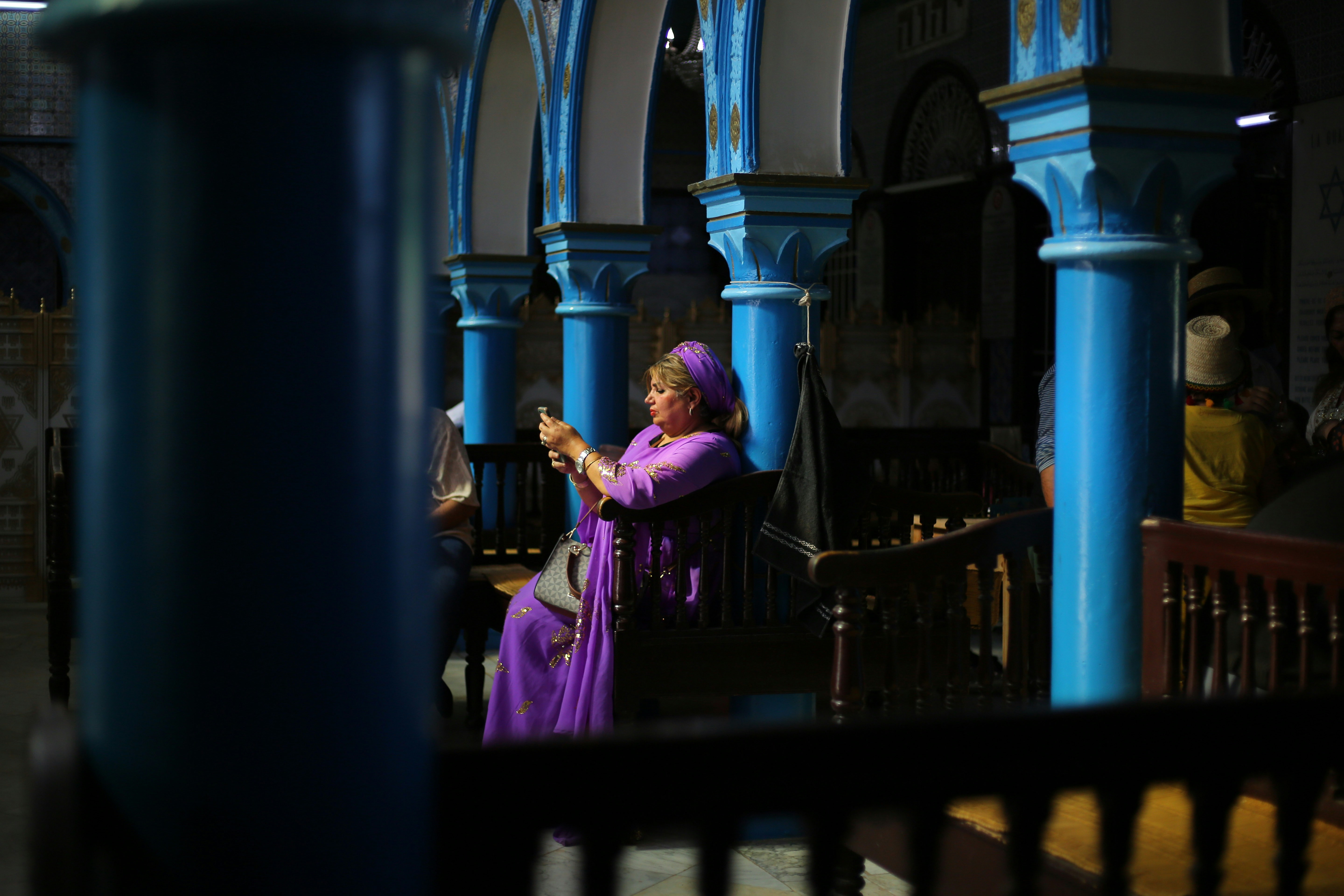 Purple-clad spectator under blue arches, capturing the moment