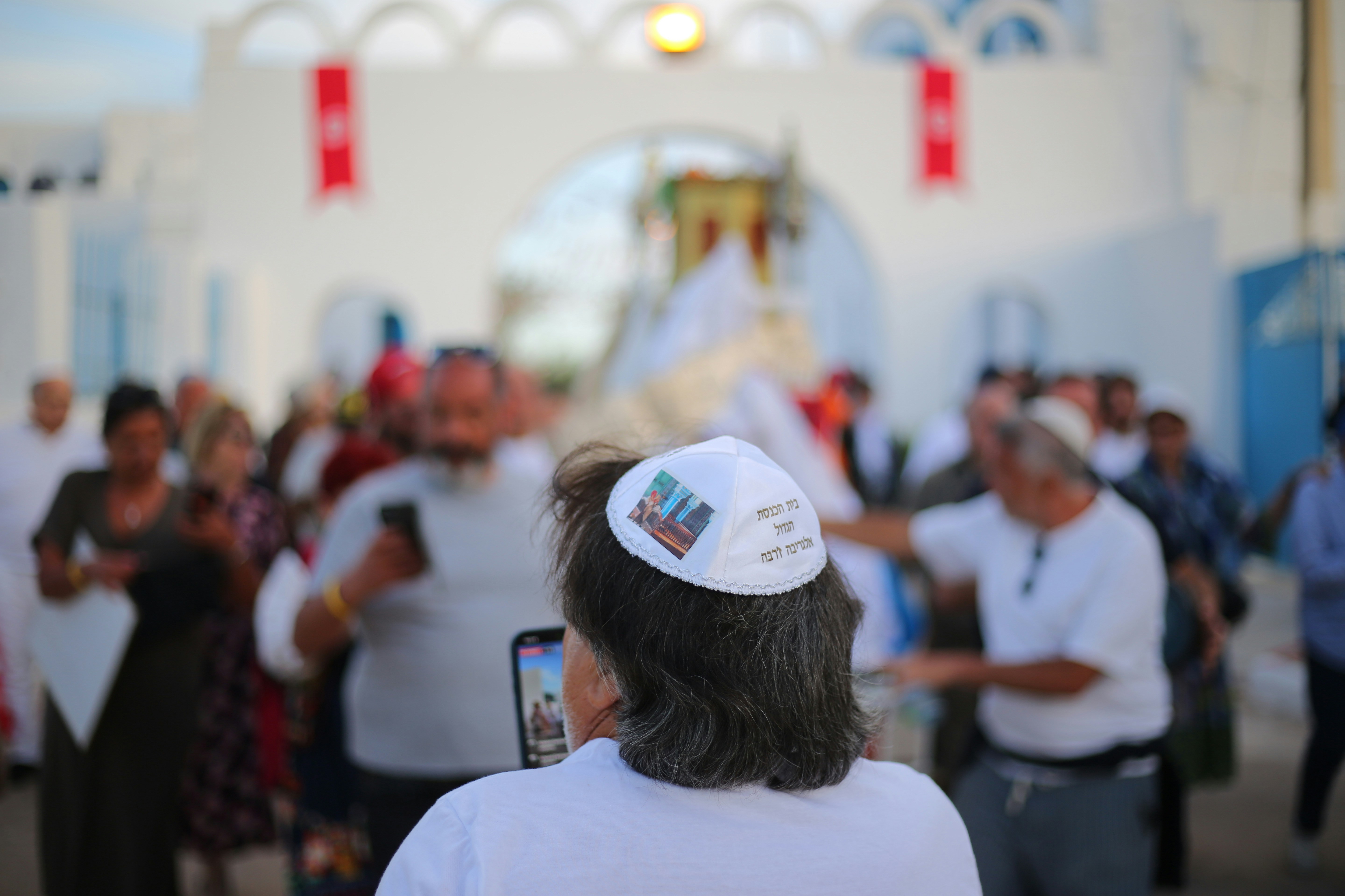 A Quiet Note on the Back: A performer with a white cap facing a crowd