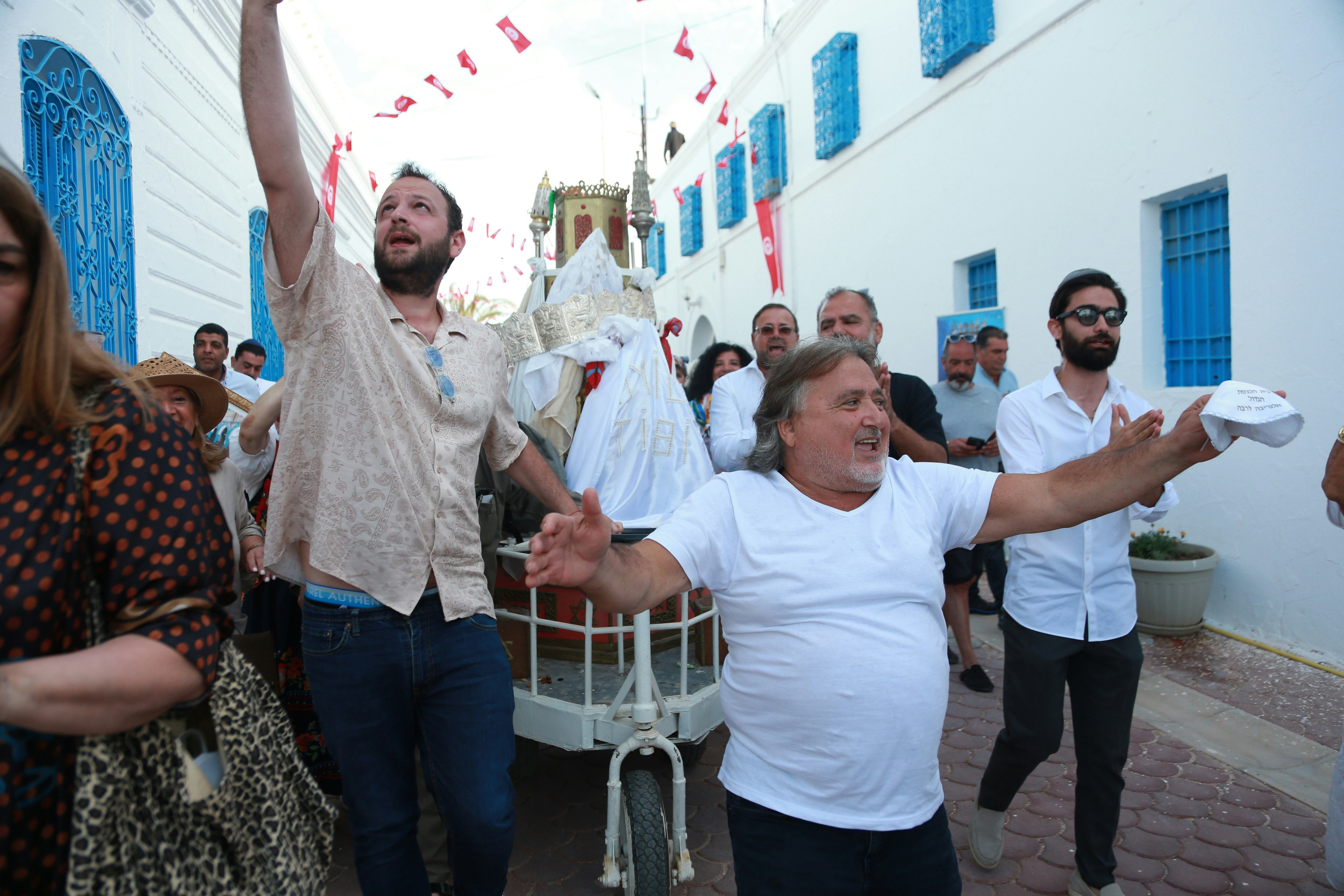 Onlookers Rally for a Religious Procession Through a Narrow Blue-Walled Street