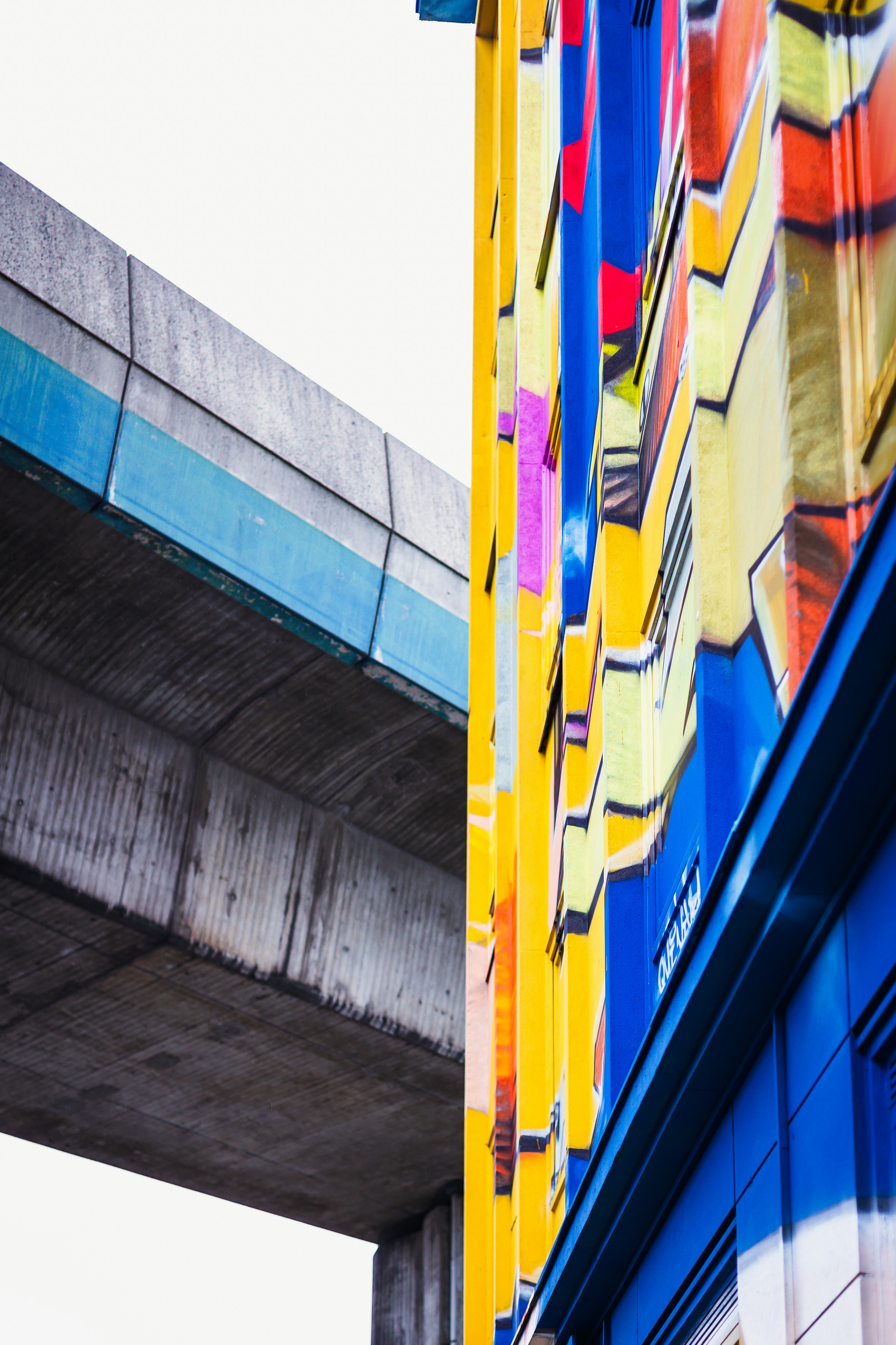 Chromatic Facade: A Striped Burst Along the Urban Overpass