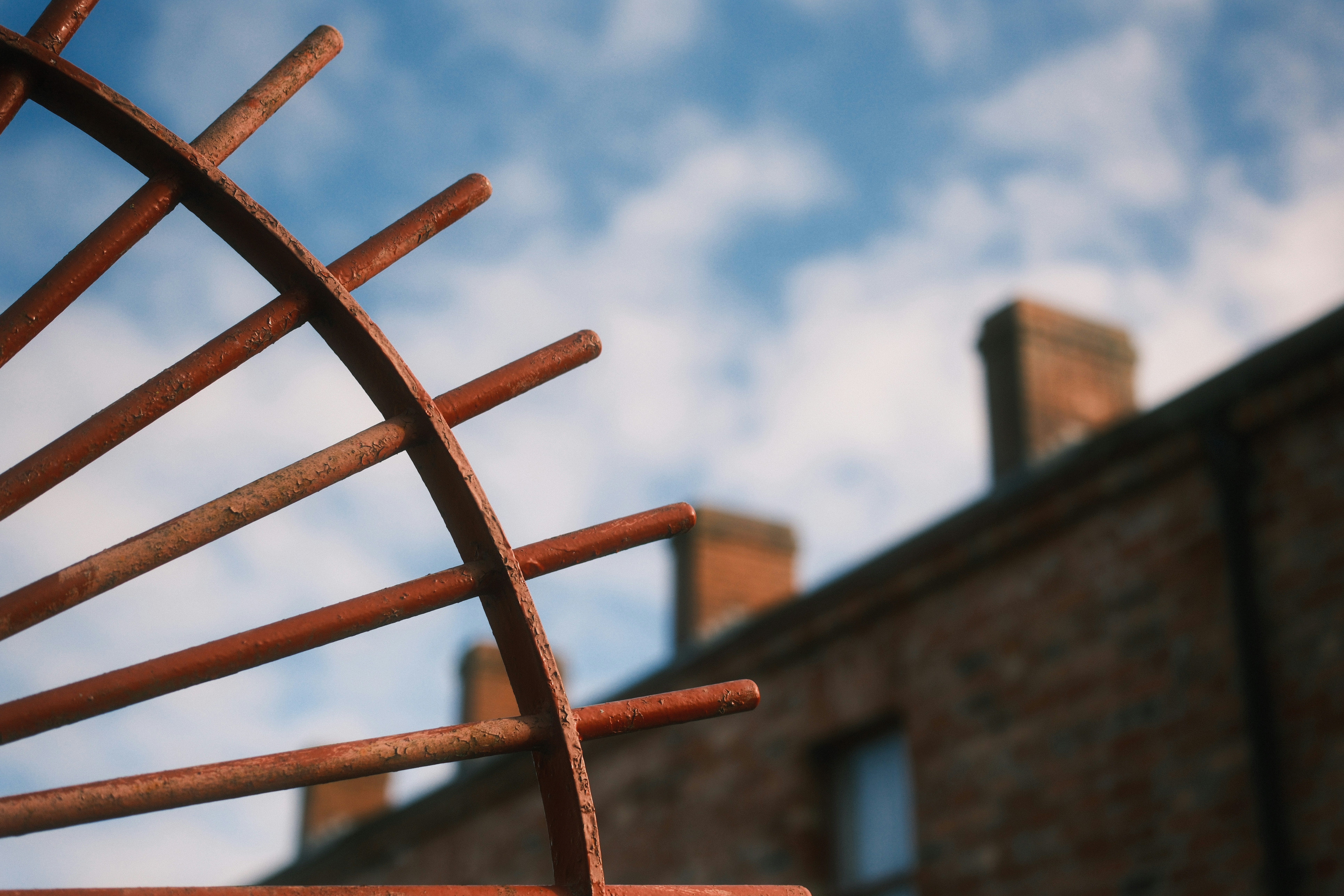 Rusted Arch Framing a Distant Brick Rooftop