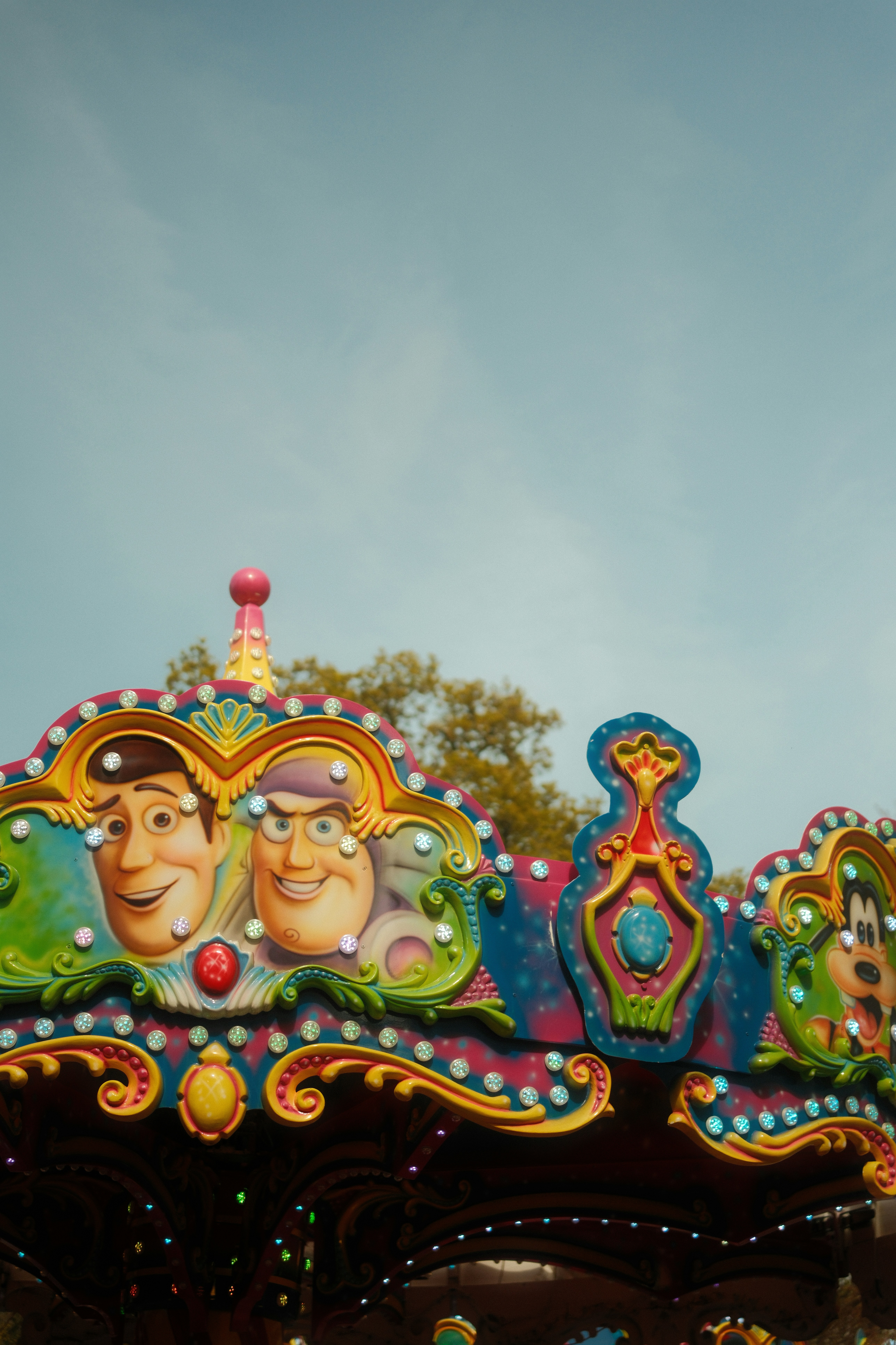 Carved Carousel Faces Under a Sky of Soft Blue