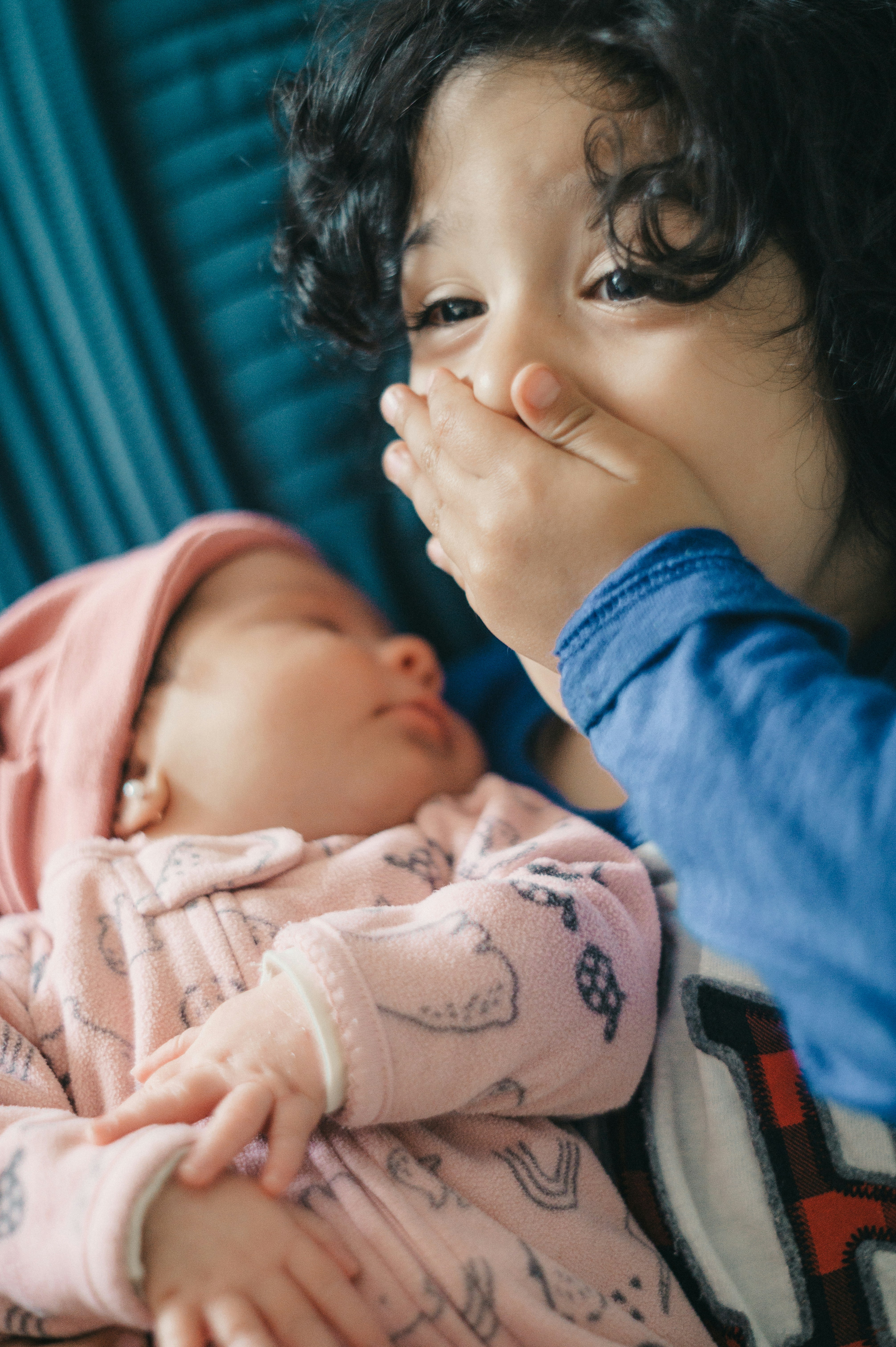 Quiet Moment Between Siblings: A Baby's Morning Gaze