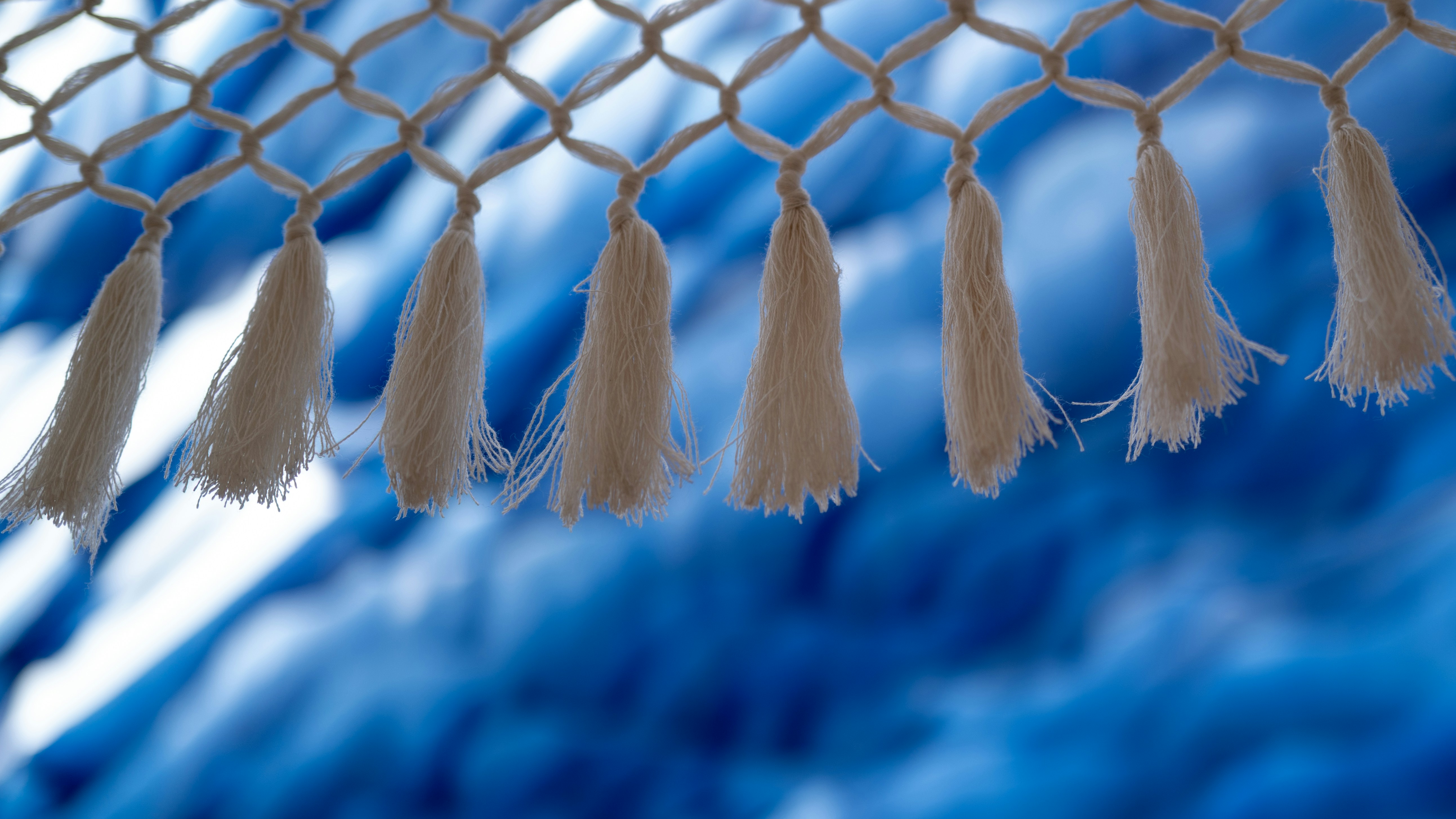 Frayed Threads Against a Deep Blue Silk Backdrop