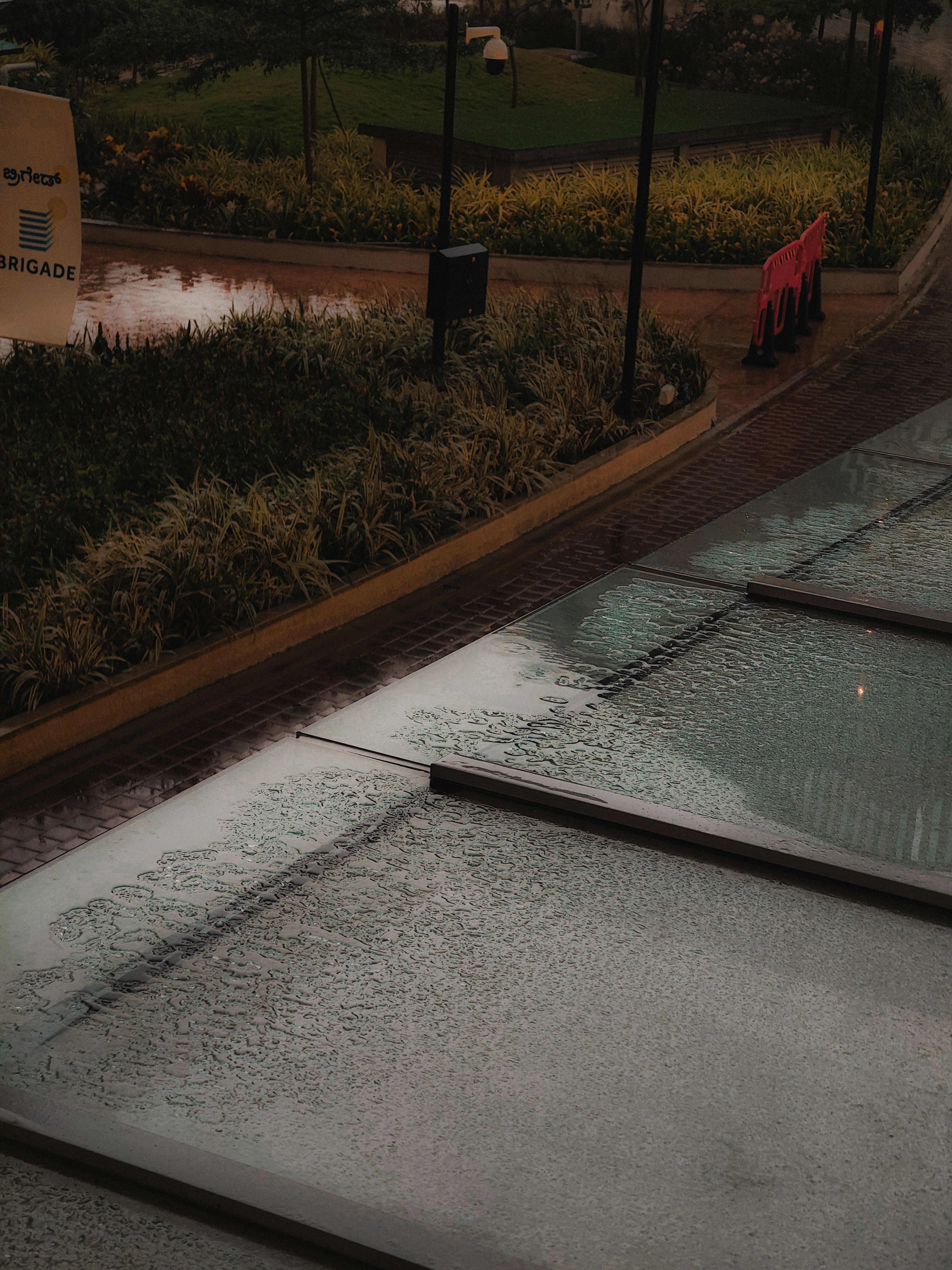 Night Walkway: Wet Glass Panels Reflect a Quiet Park Edge