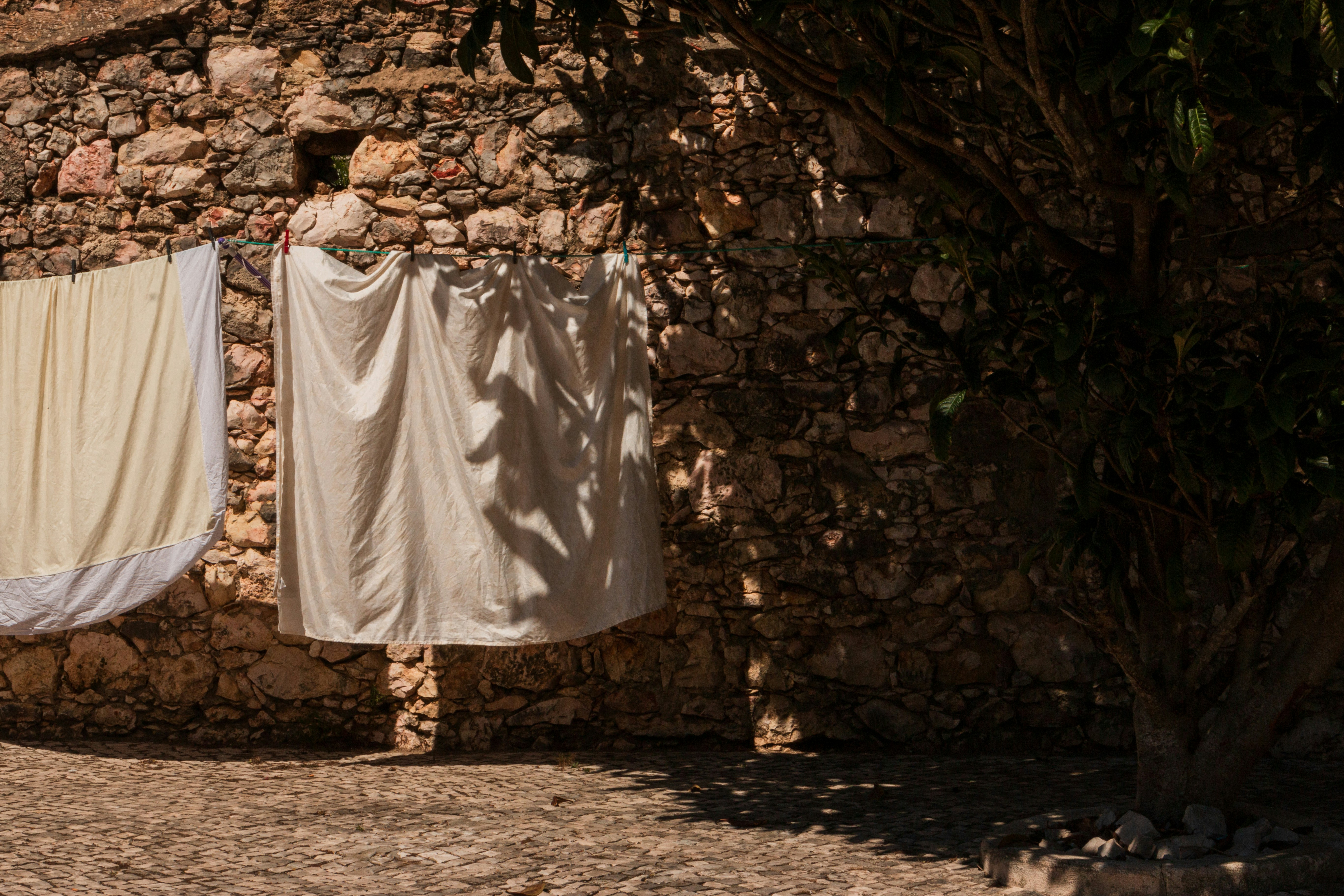 Sunlit Laundry Against an Aged Stone Wall