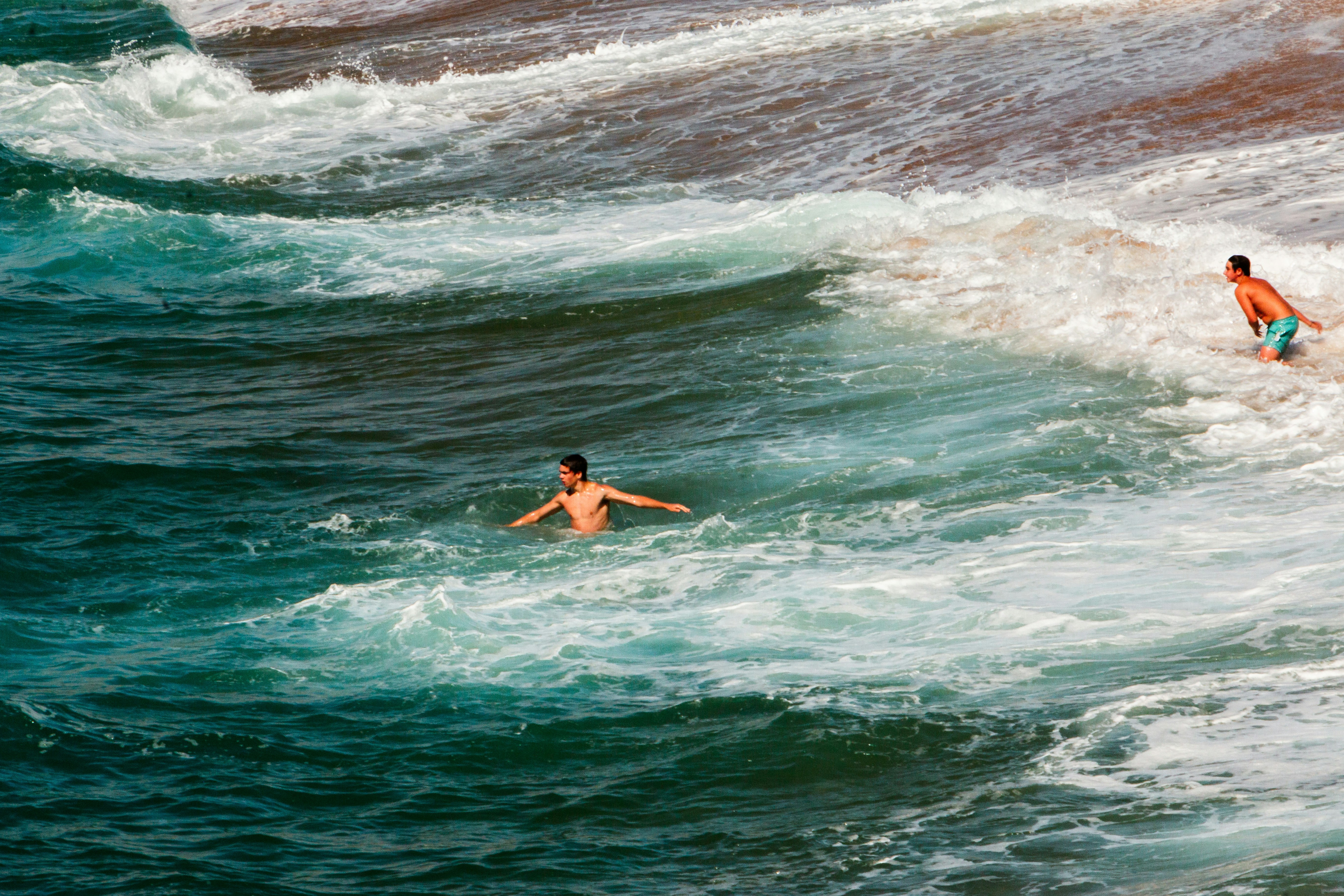 Two Surfers Navigate a Crew-cut Crest in Turquoise Ribbons