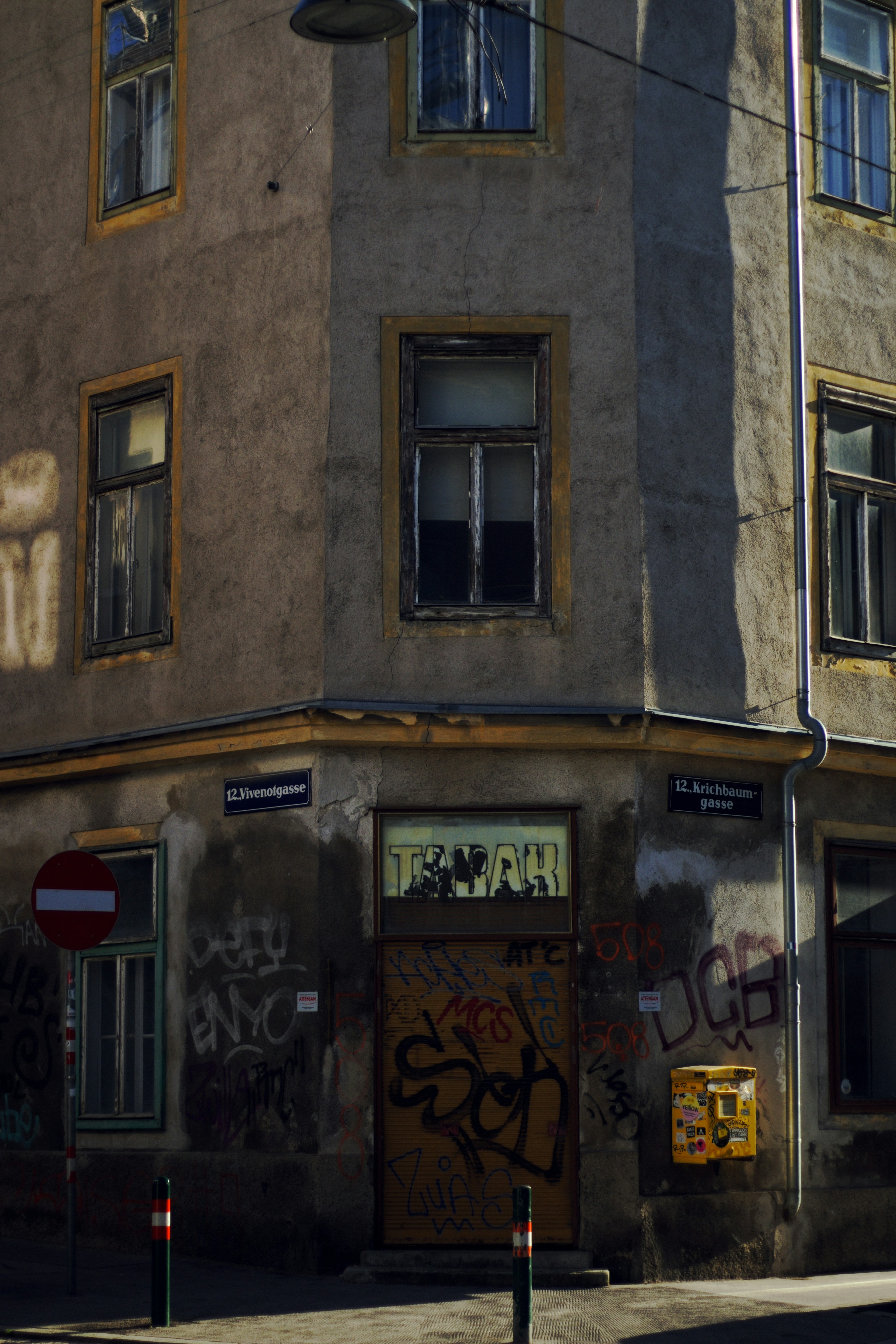 Urban Corner: Graffiti-Soaked Facade with Dim Entrances