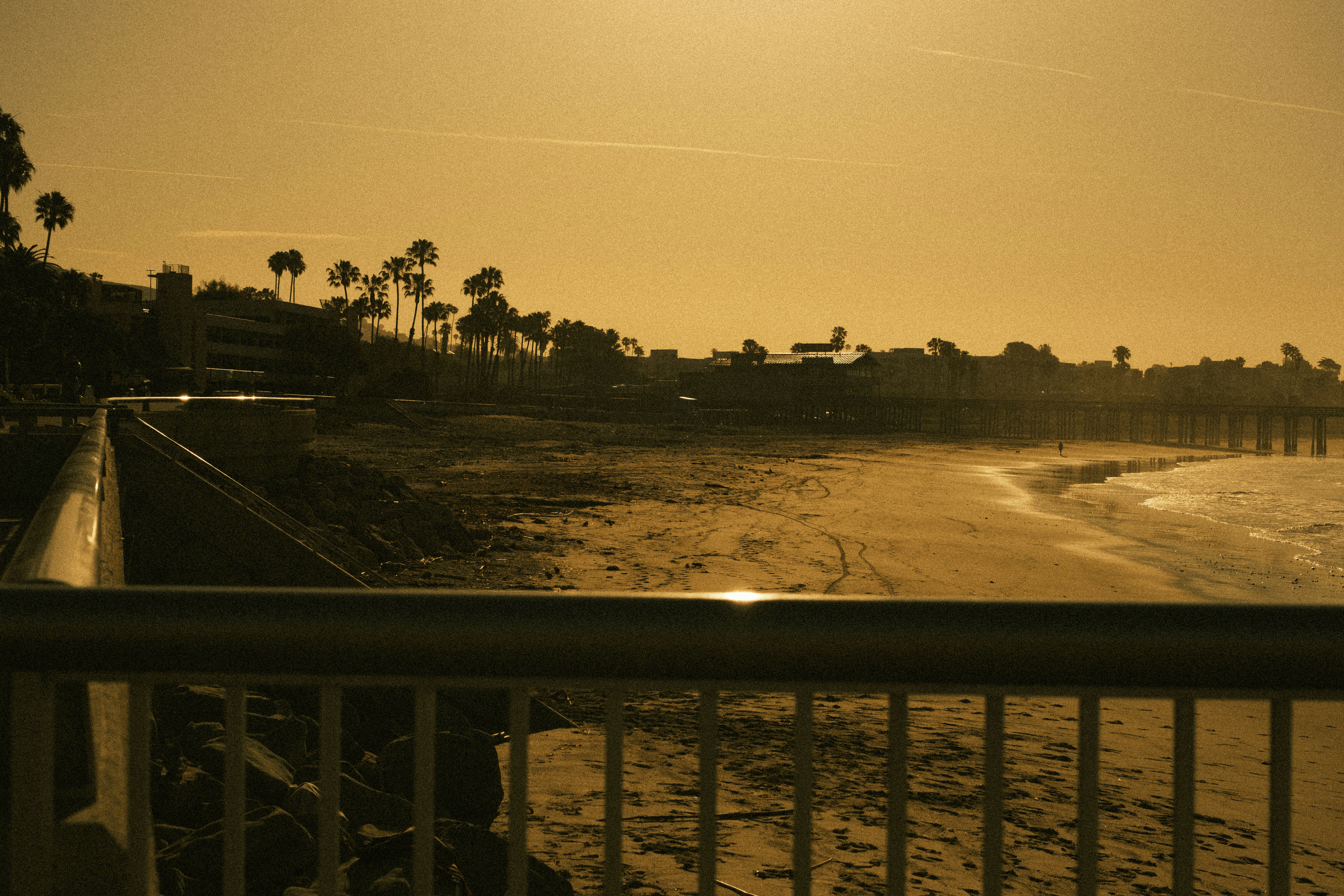 Golden Hour Over the Pier: Coastal Rail and Twilight Tide