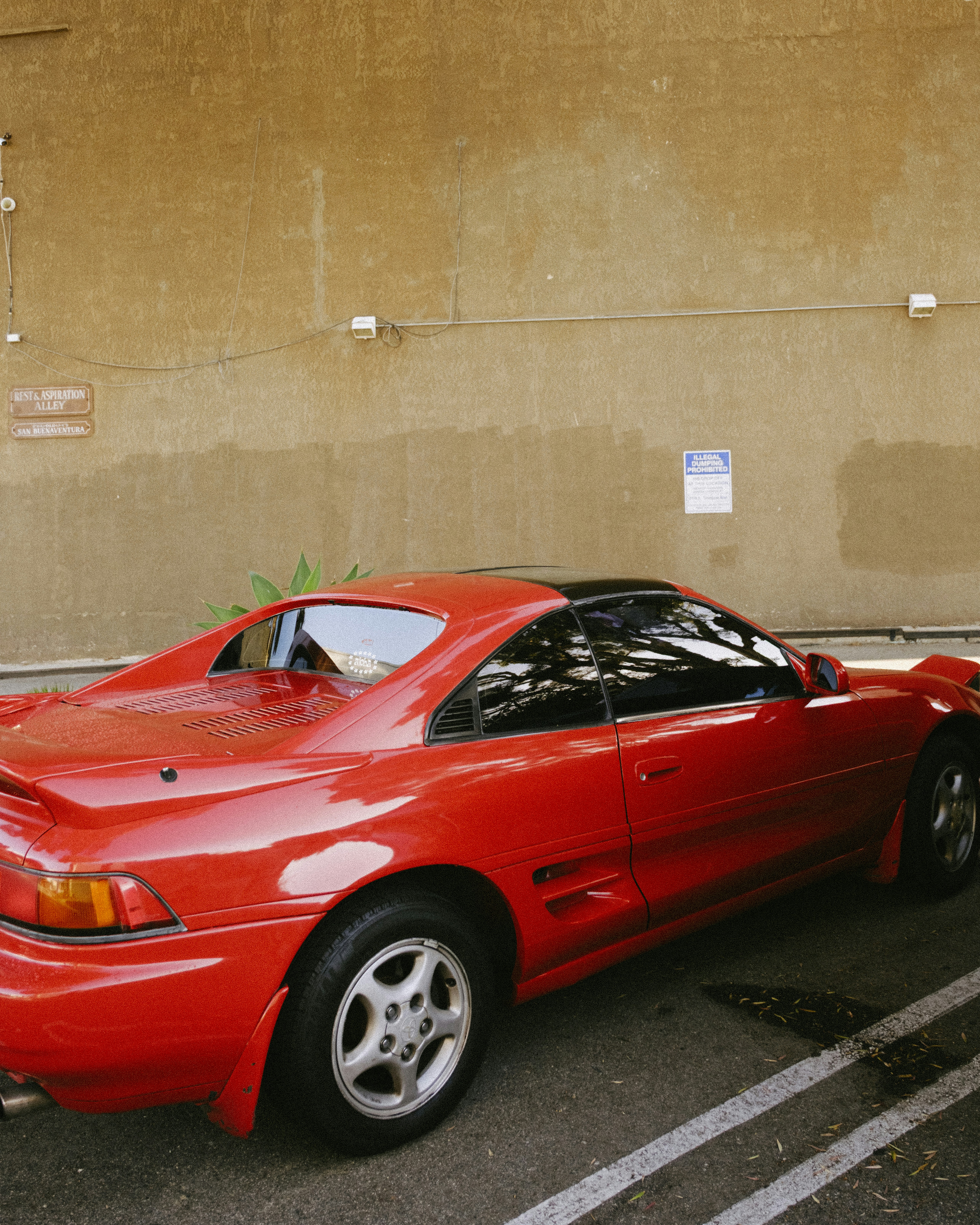 Red Classic in an Empty Alley: The Sleek Curves of a Sports Car
