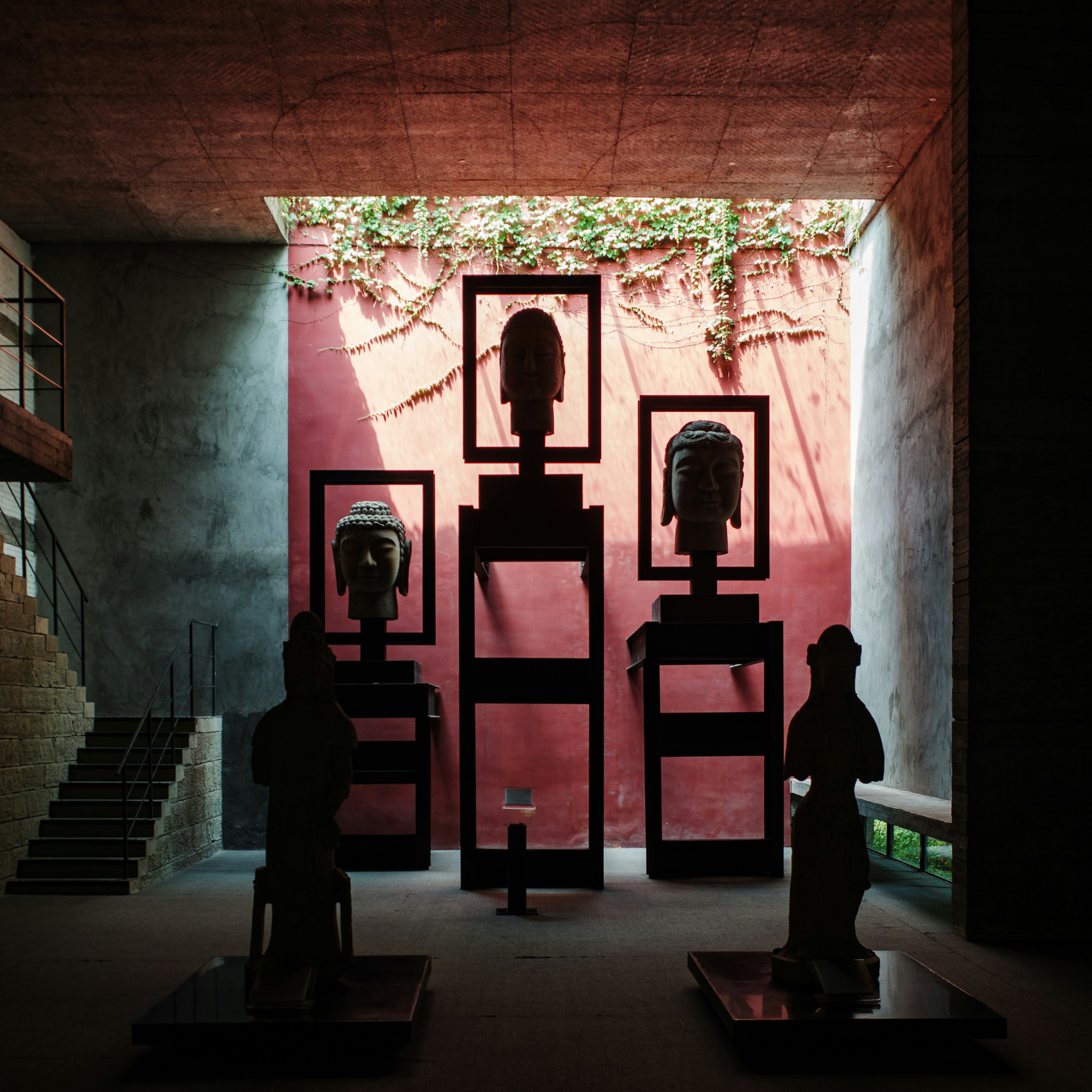 Shadowed Heads, Framed Heights: Sculptures in a Pink Gallery Atrium