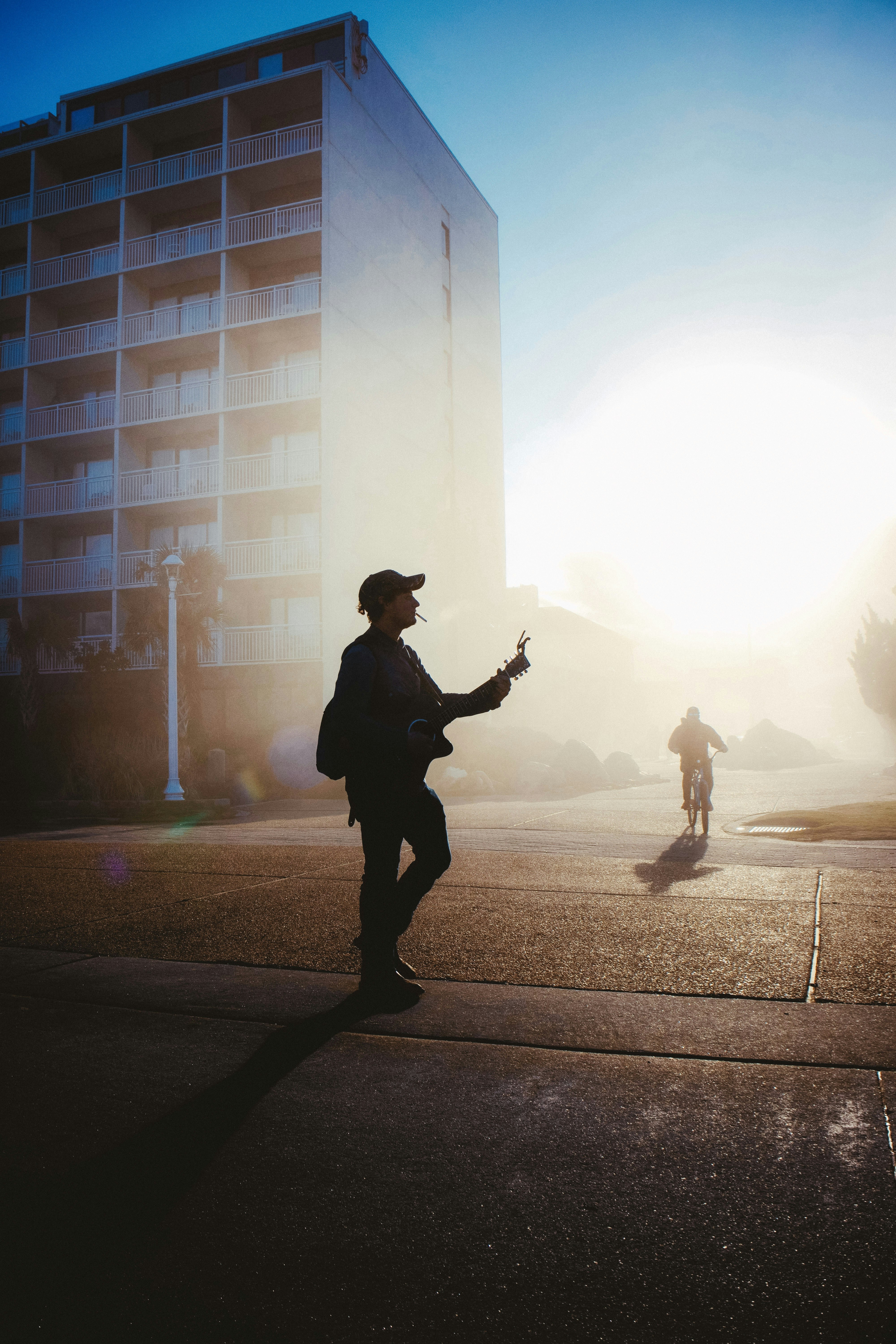 Sunlit silhouette and rider amid fog on a quiet promenade
