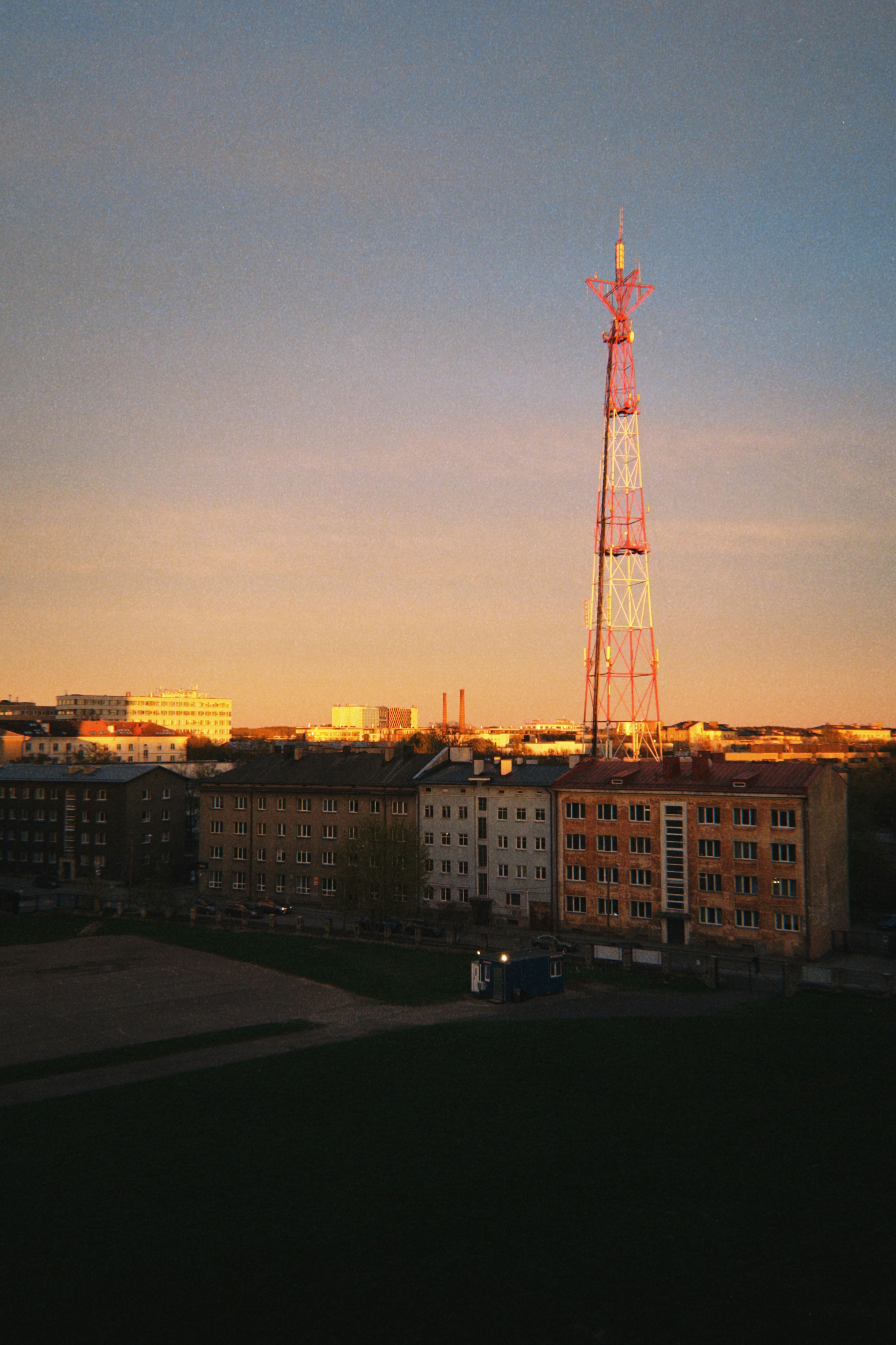 Cityscape at Golden Hour with a Prominent Communication Tower