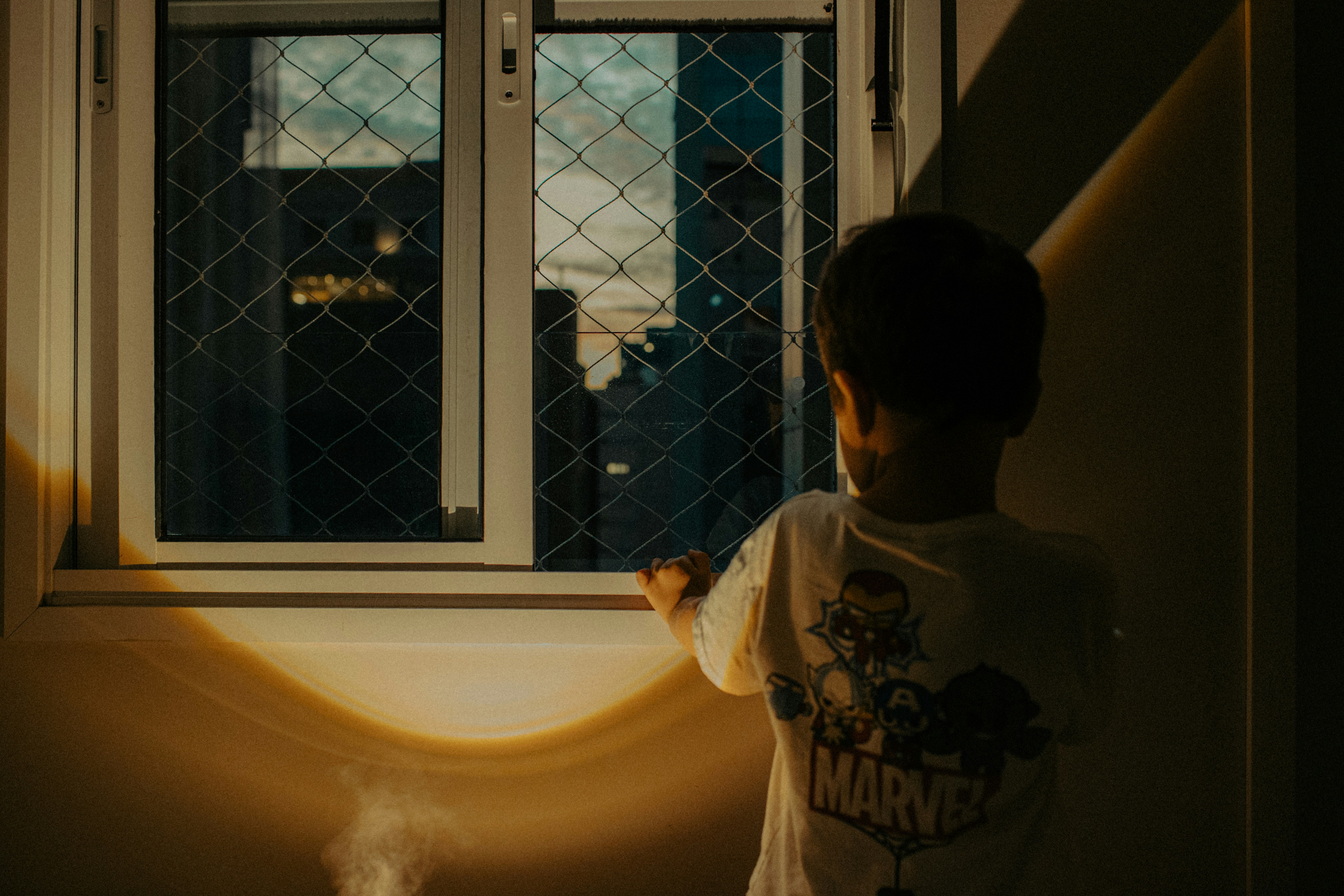 Moonlit Window: A Child's Quiet Gaze Toward the City