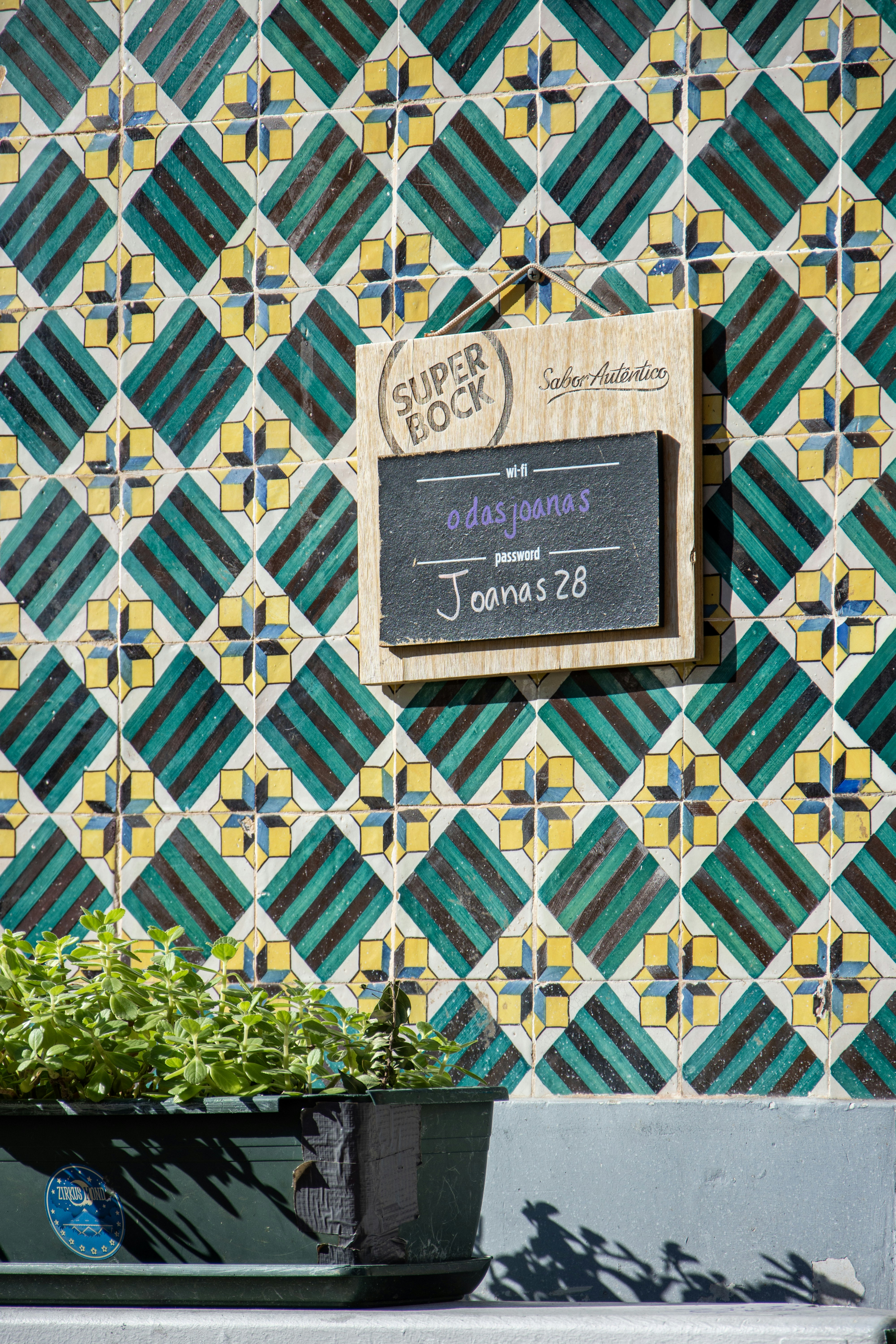 Colorful Tile Mosaic as Wall Backdrop with Wooden Signboard