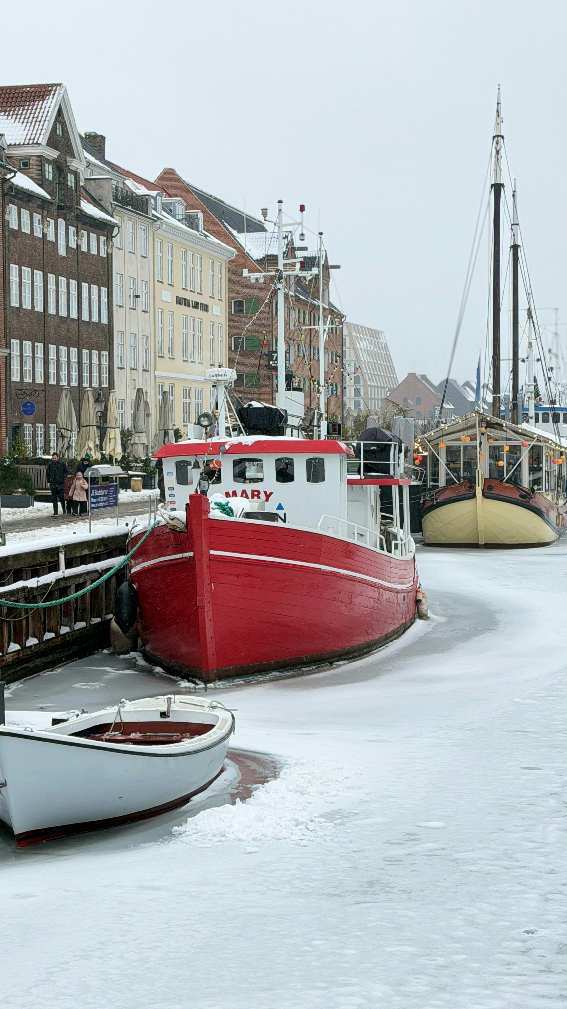 Crimson Boat at a Snow-kissed Danish Harbor