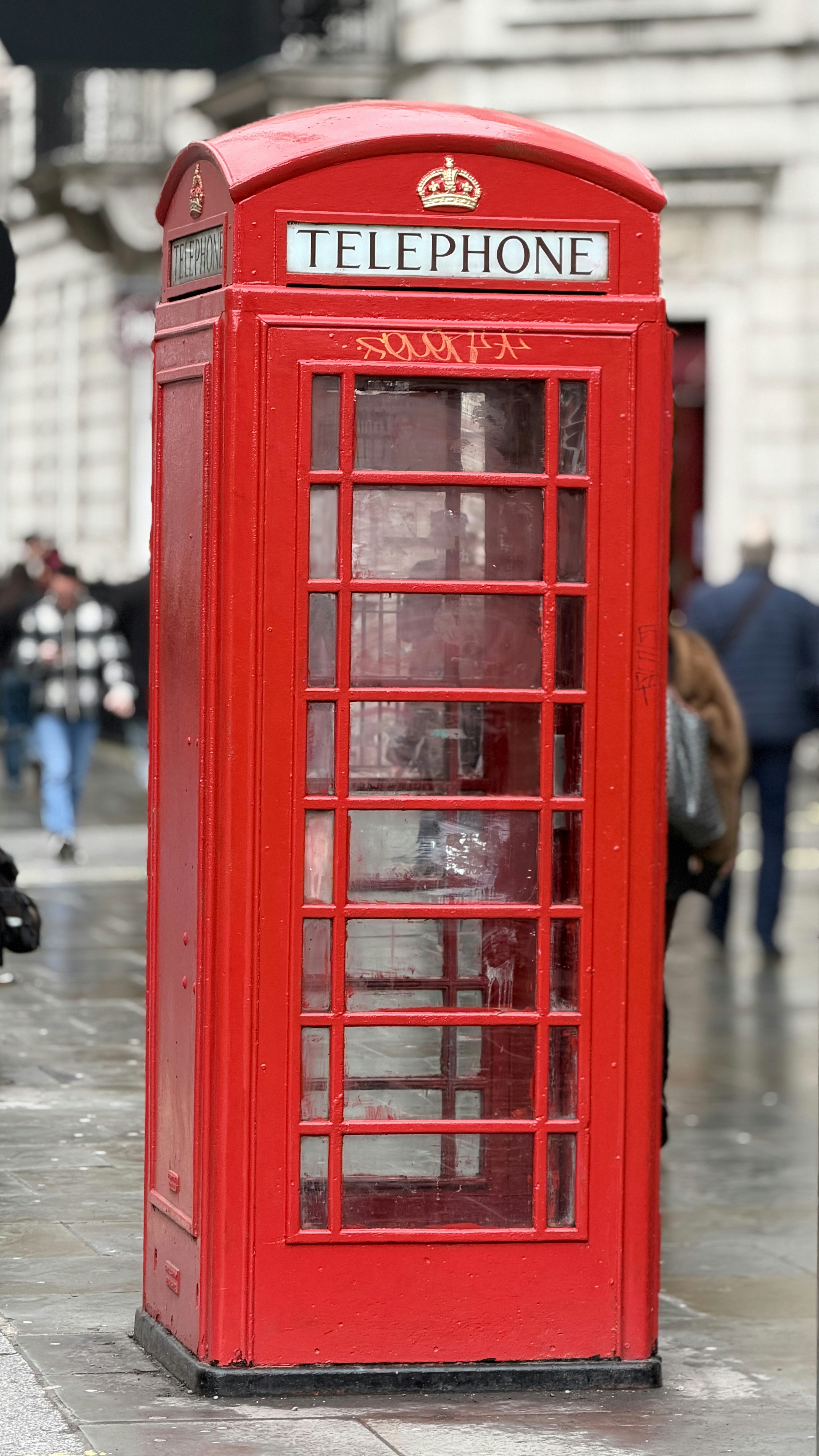 Crimson Beacon: A Classic Red Telephone Box on a Bustling City Street