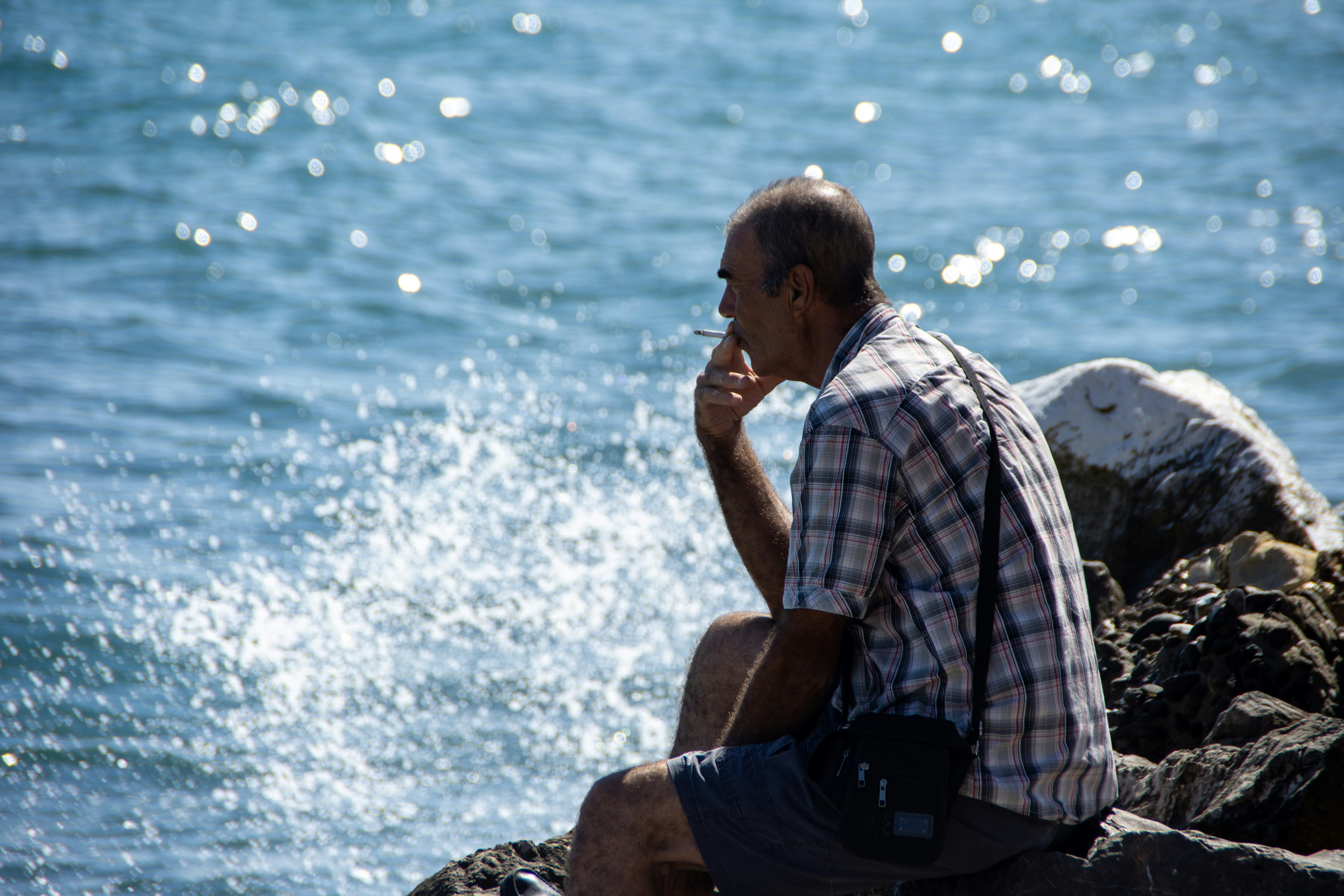 Solitary Figure on the Rocks: A Quiet Exchange with the Sea
