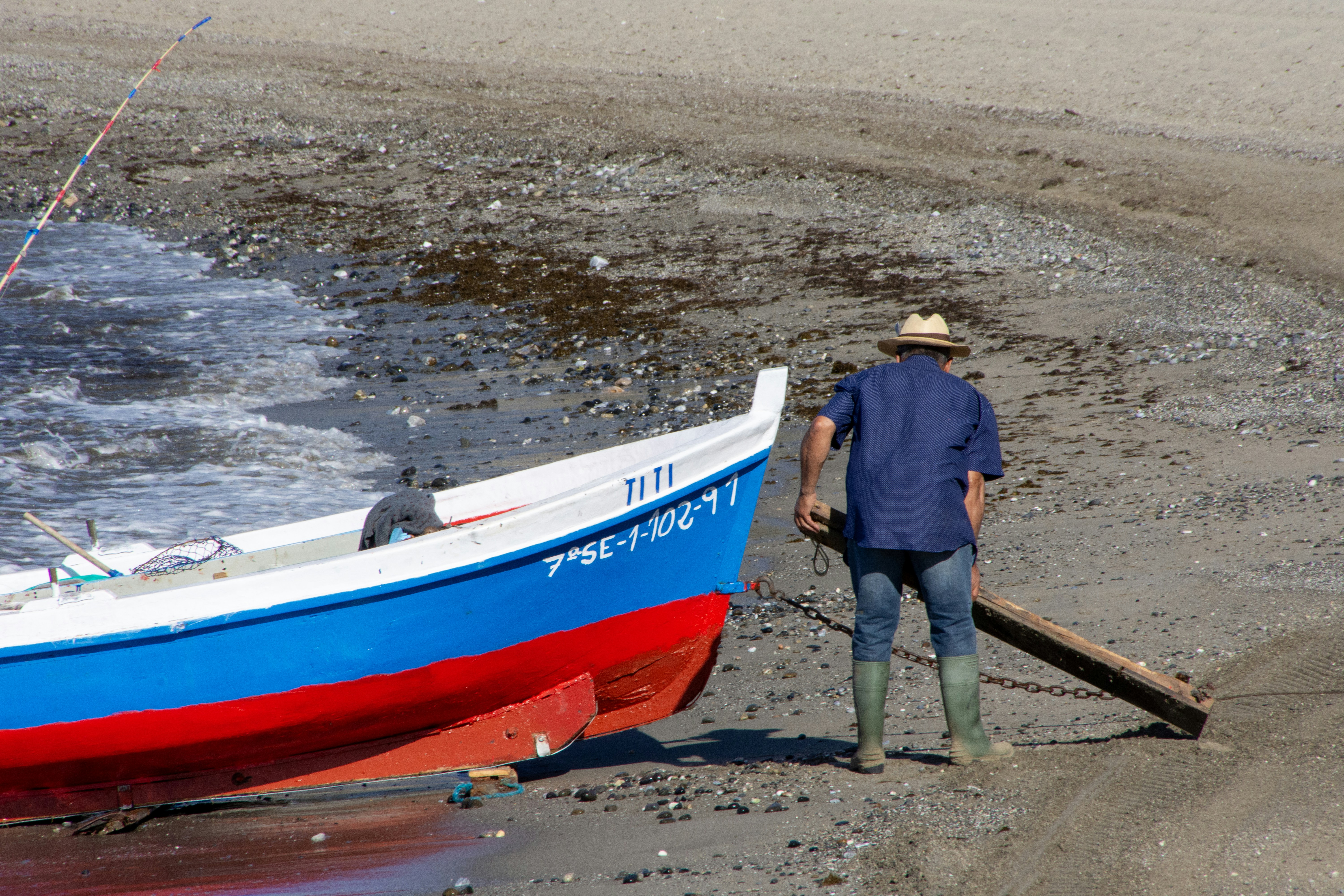Toward the Tide: A Fisherman and his Boat on a Shallow Shore