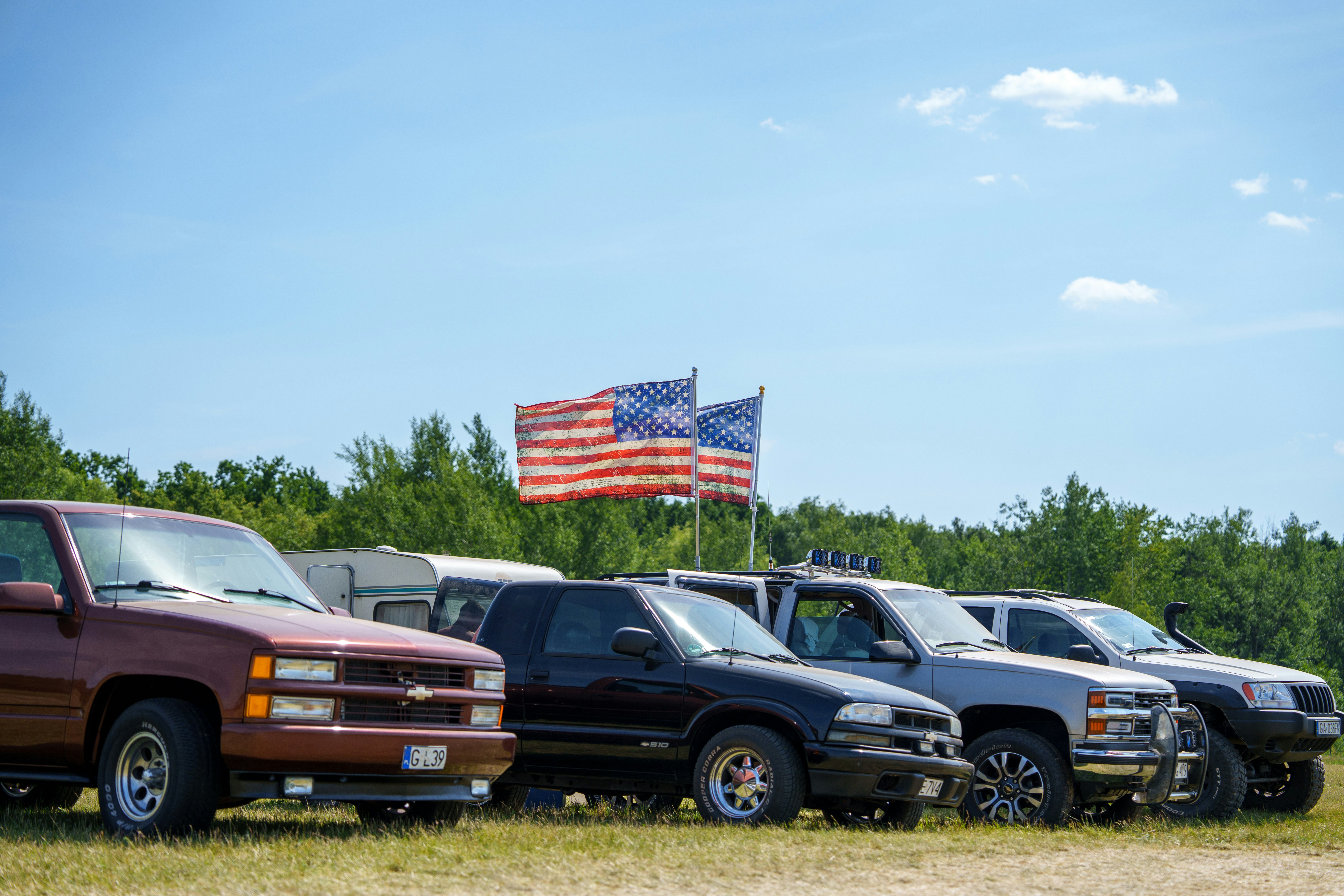 Patriotic Parking Lot: Flags Flutter Over a Line of Pickup Trucks