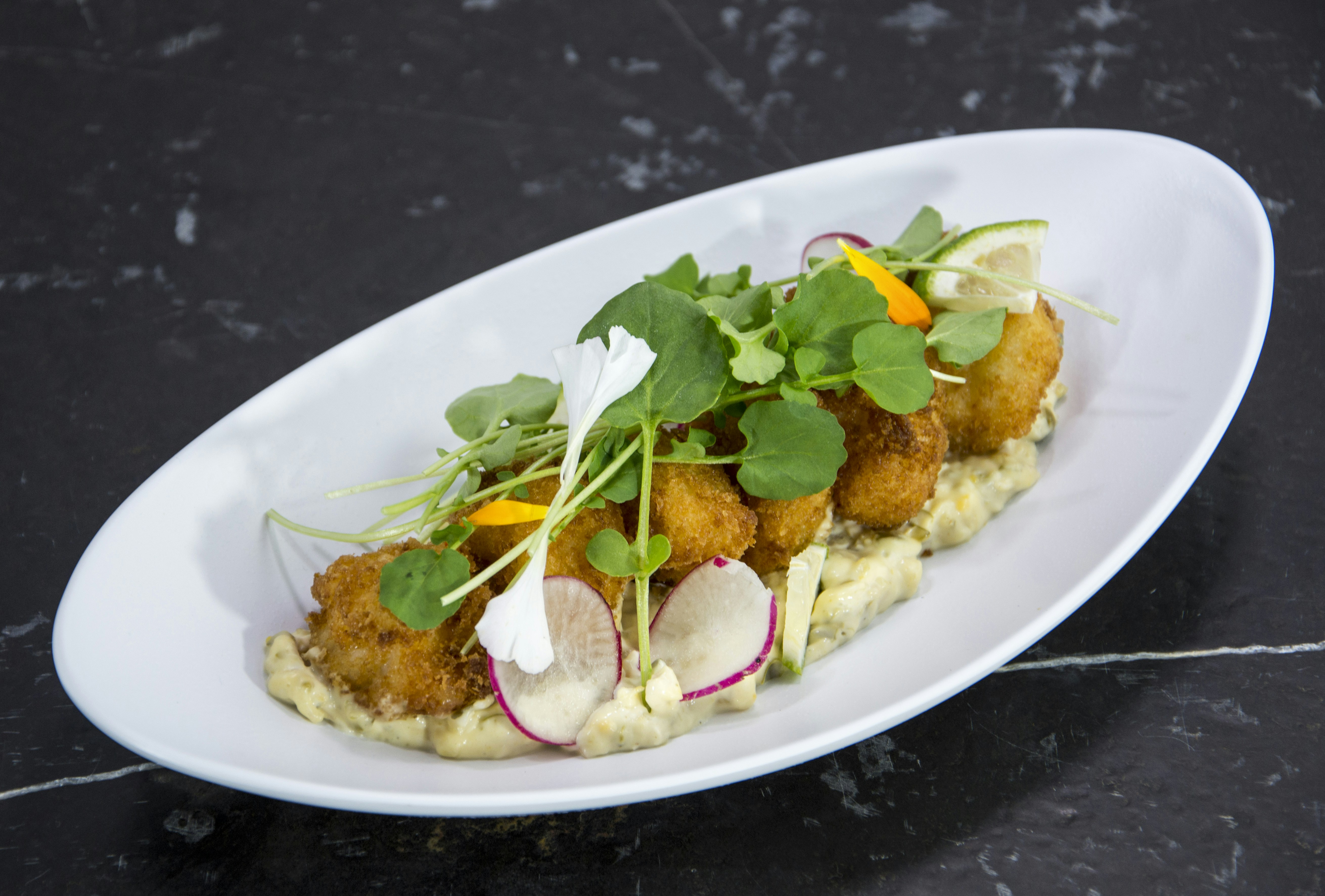 Crisped bites on a cloudbed of creamy spread with microgreens