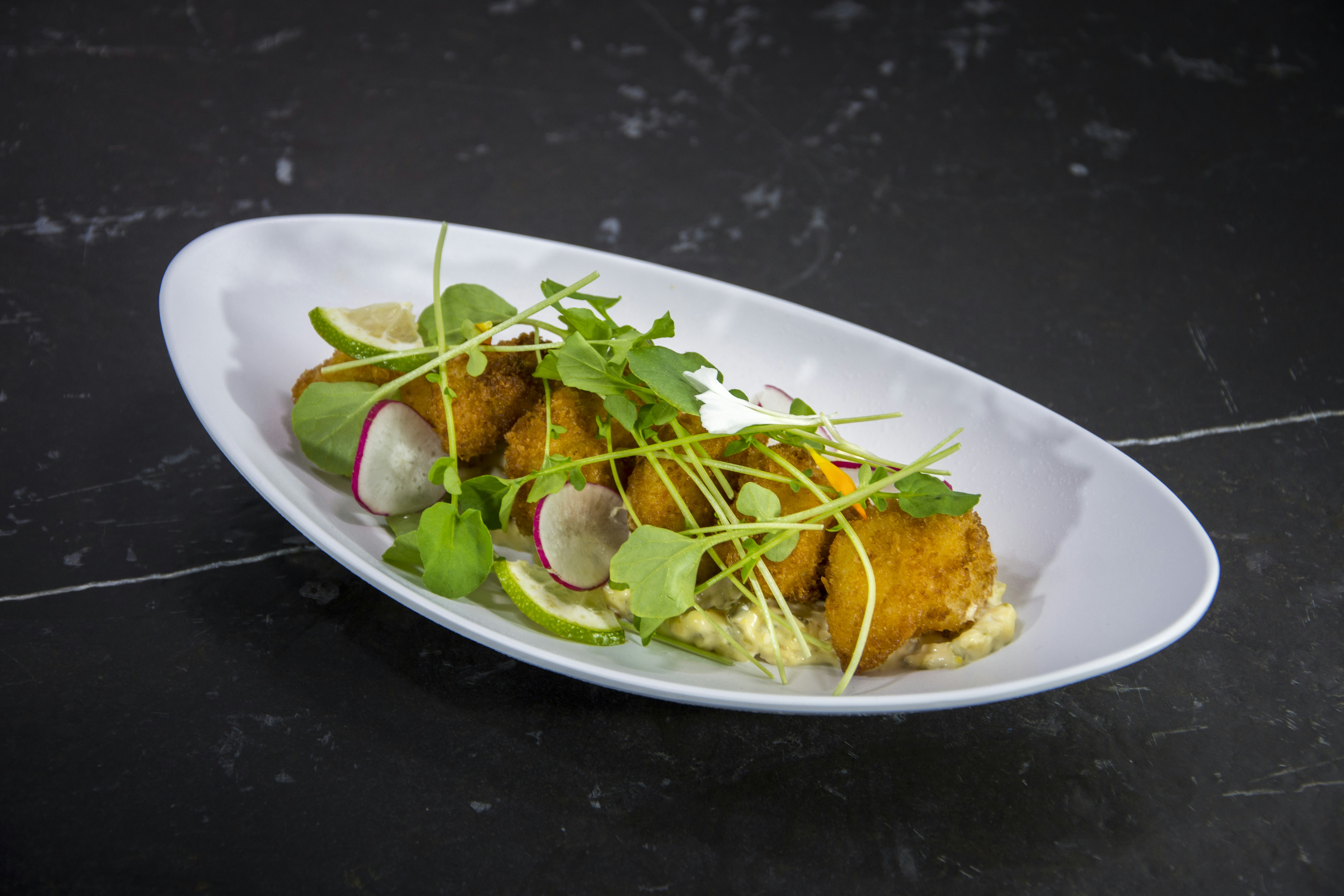 Gold-crusted seafood bites on a herb-carved canvas