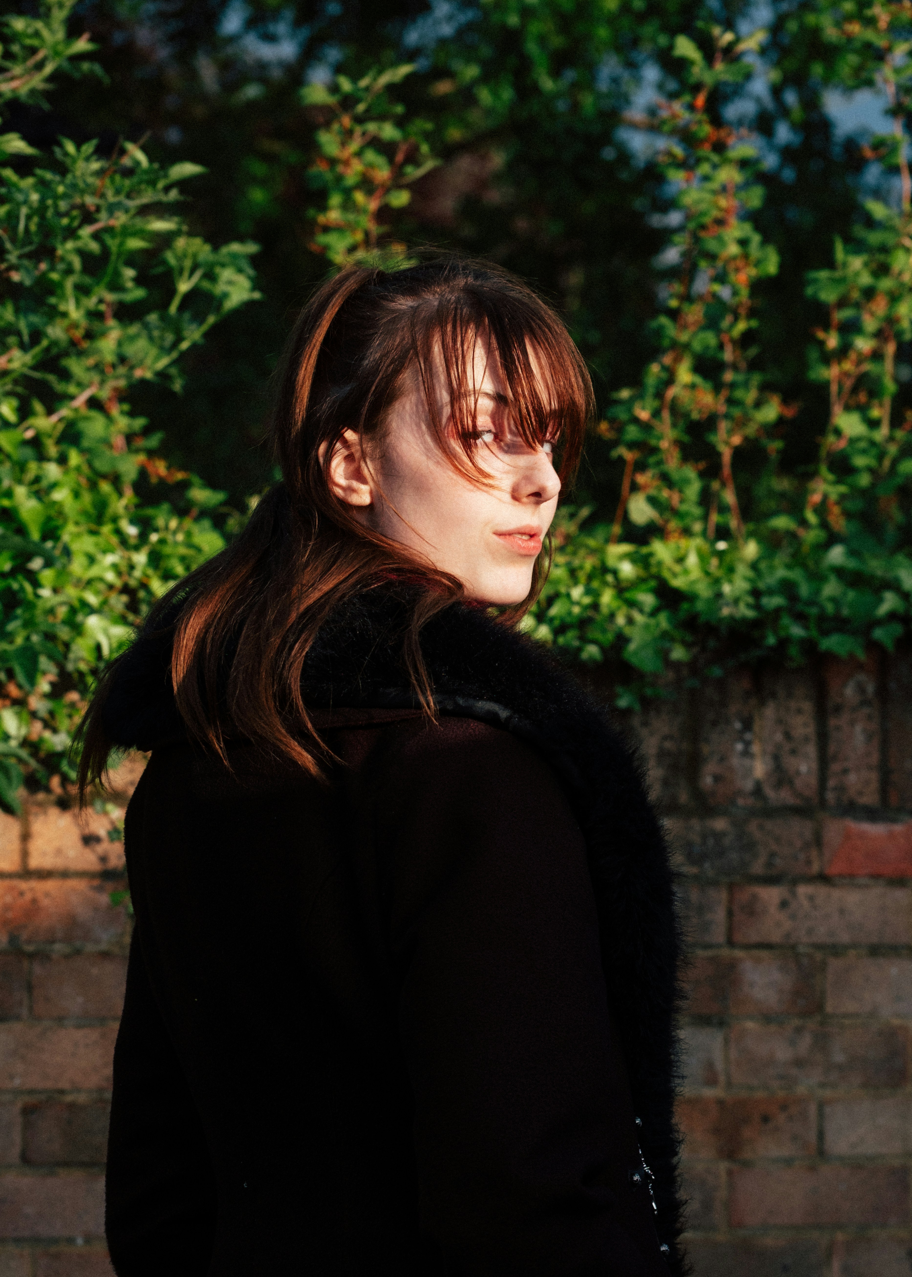 Soft Light, Strong Presence: A Portrait by the Brick Wall Garden