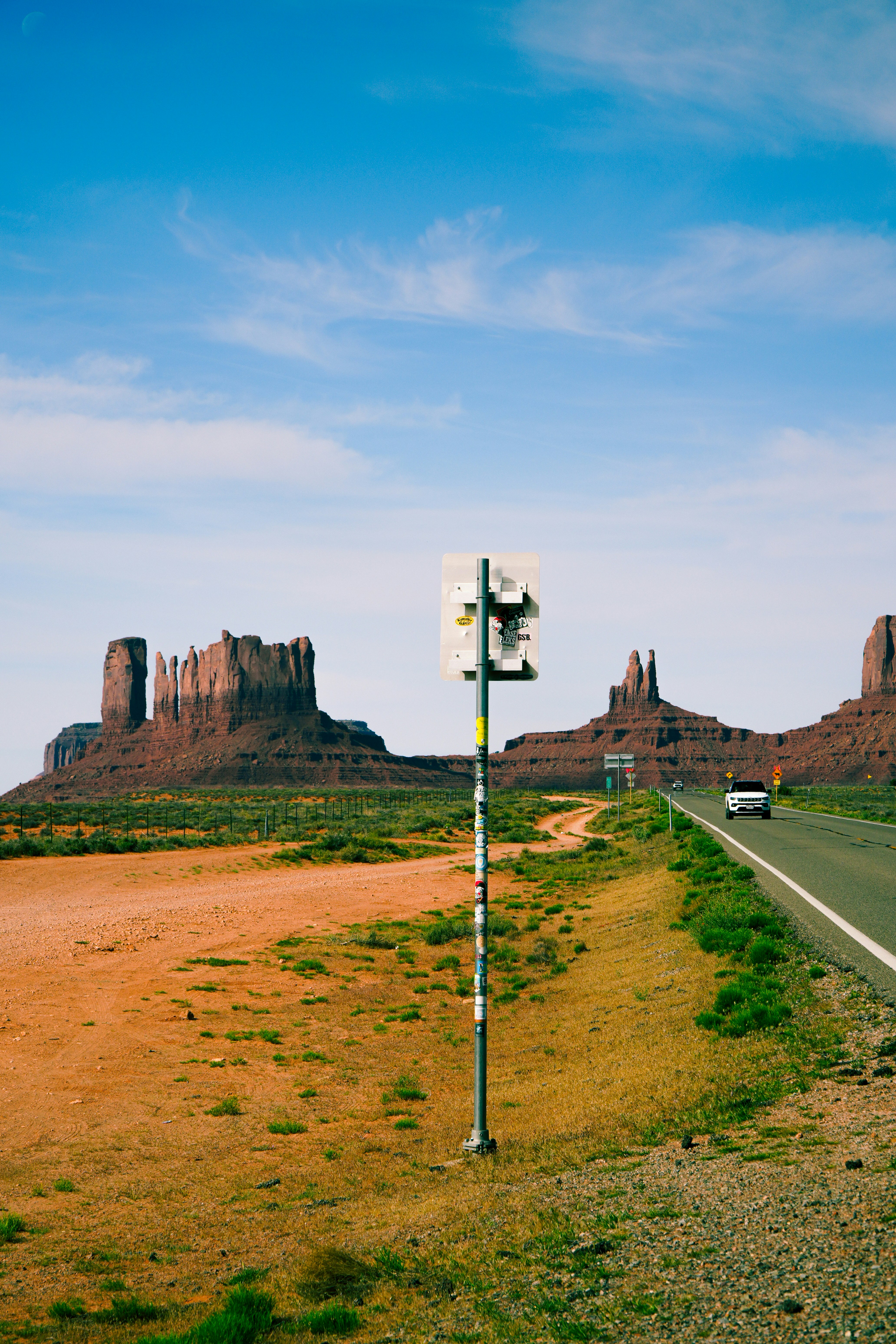 Lonely Signpost and Desert Monuments Along a Distant Highway