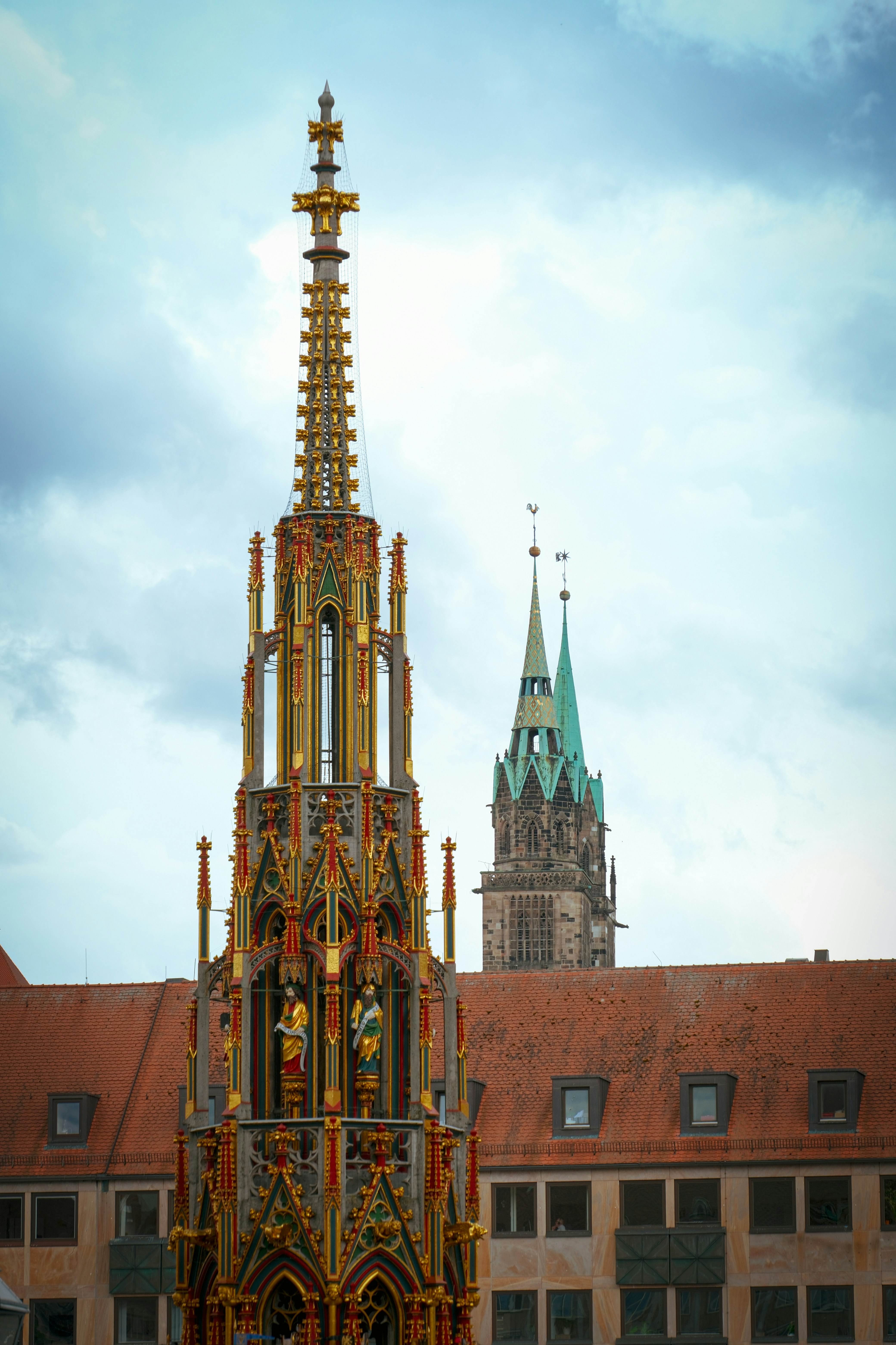 Gothicspire in Focus: A City’s Ornate Spire with a Distant Clocktower