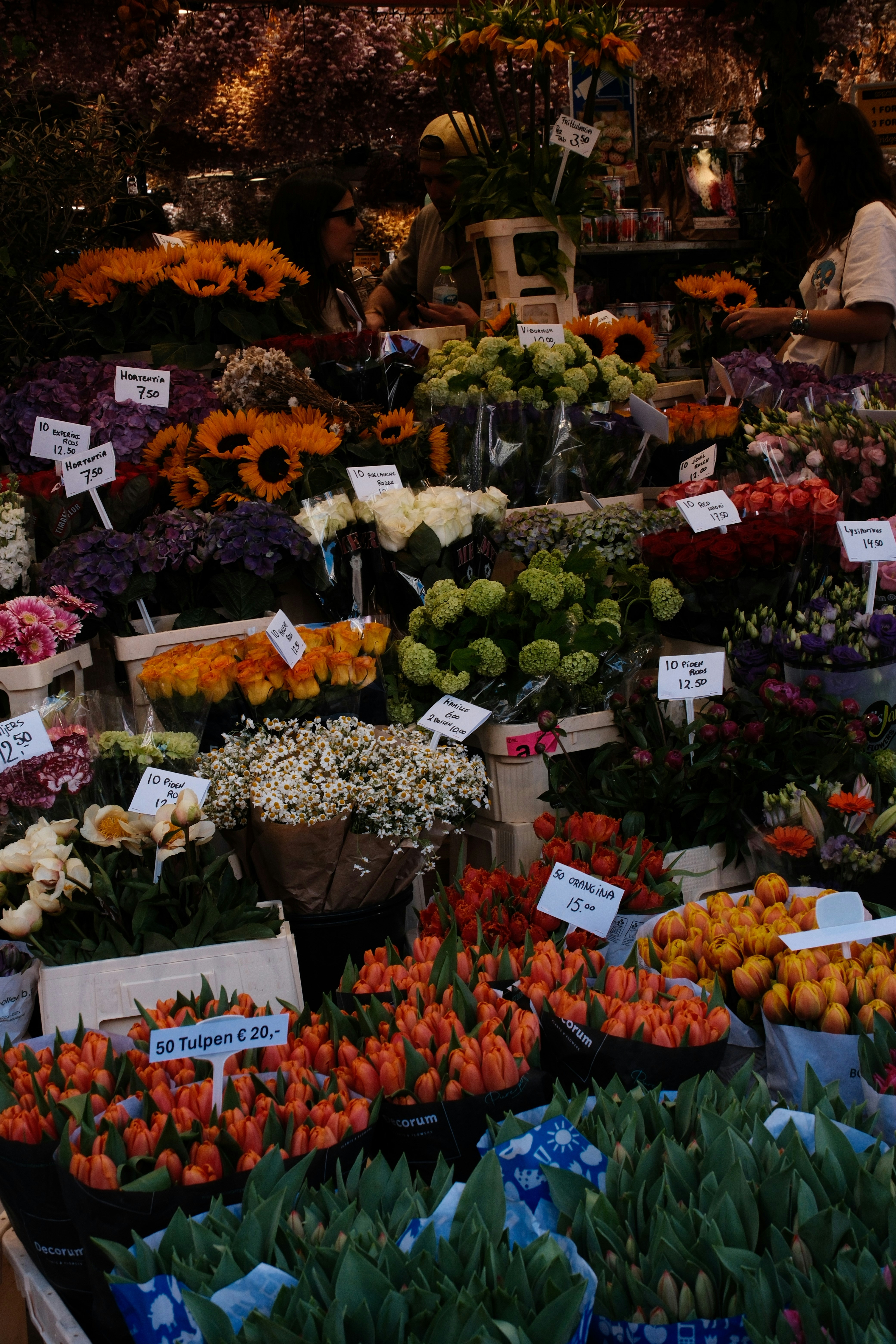 Sunlit Market Blooms: A Colorful Flower Stall Amid Gentle Evening Glow