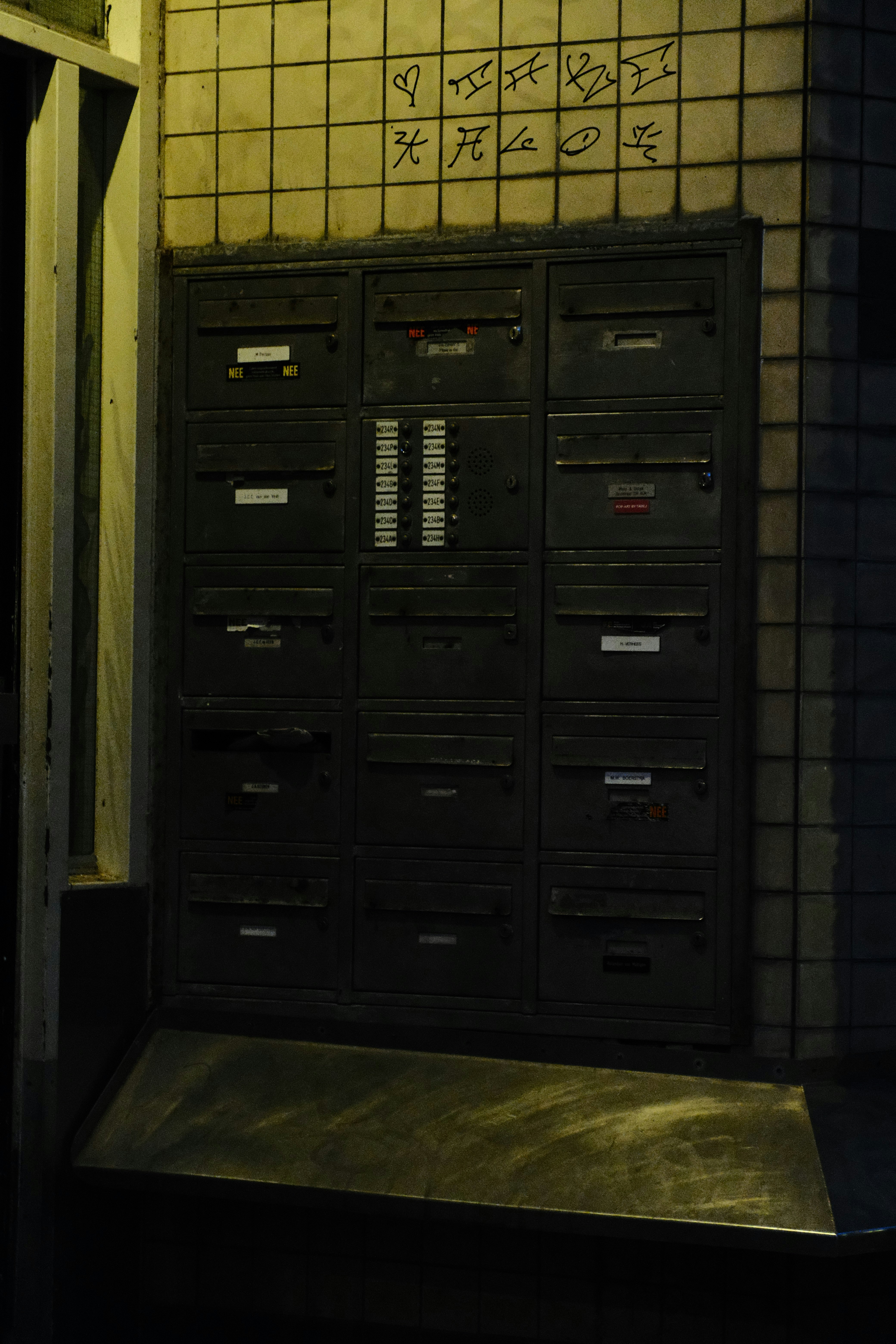 Shadowed Mailroom Facade with Cataloged Doors