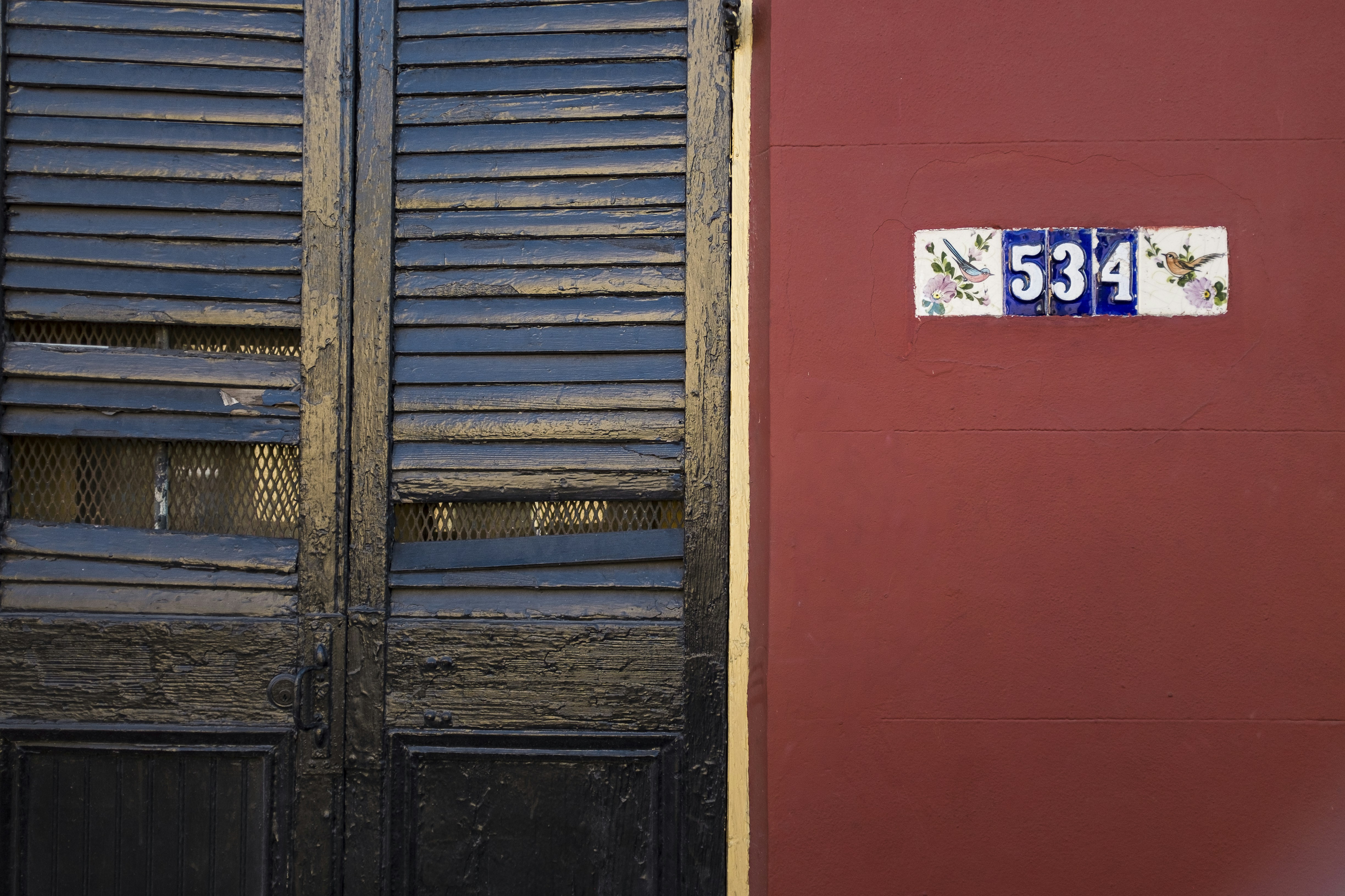 Weathered Doors and a House Number: Quiet Corner of a Red Wall