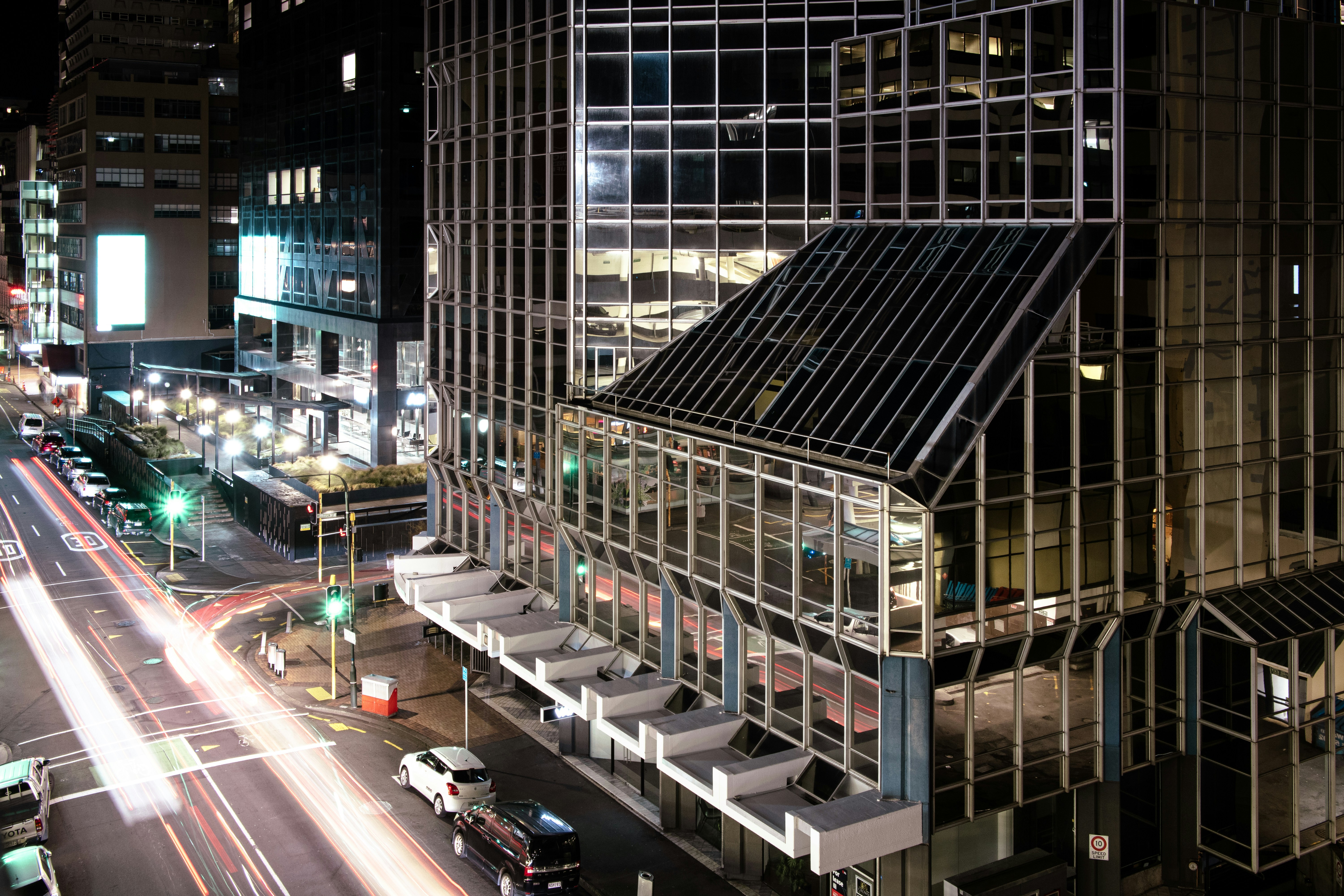 Night City Facade: Glass Grid Reflections Over a Quiet Street