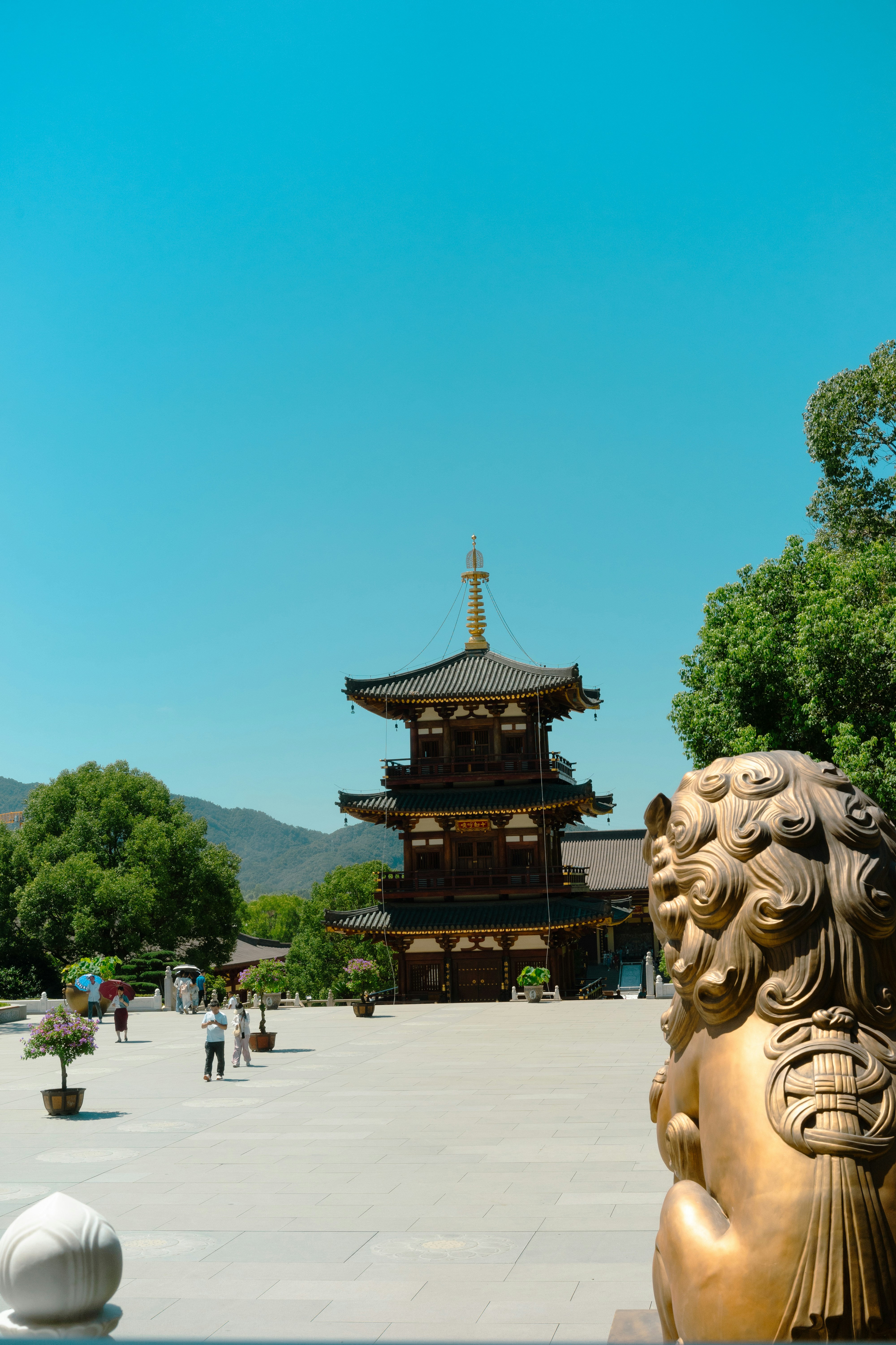 Temple in the Horizon: A Three-Tiered Pagoda Framed by a Guardian Lion
