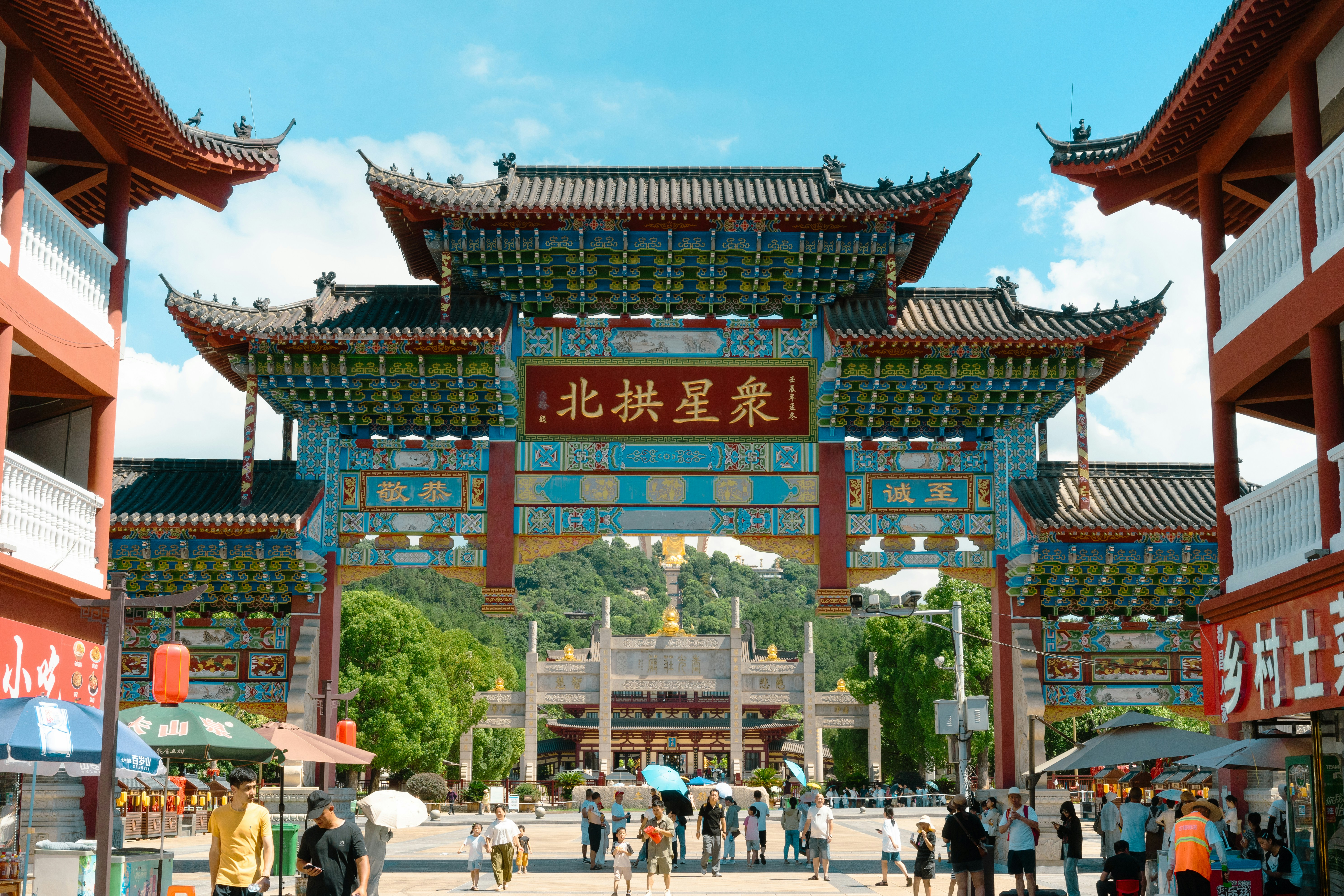 Gate of Color and Culture: A vibrant temple entrance Beneath a Sky of Blue