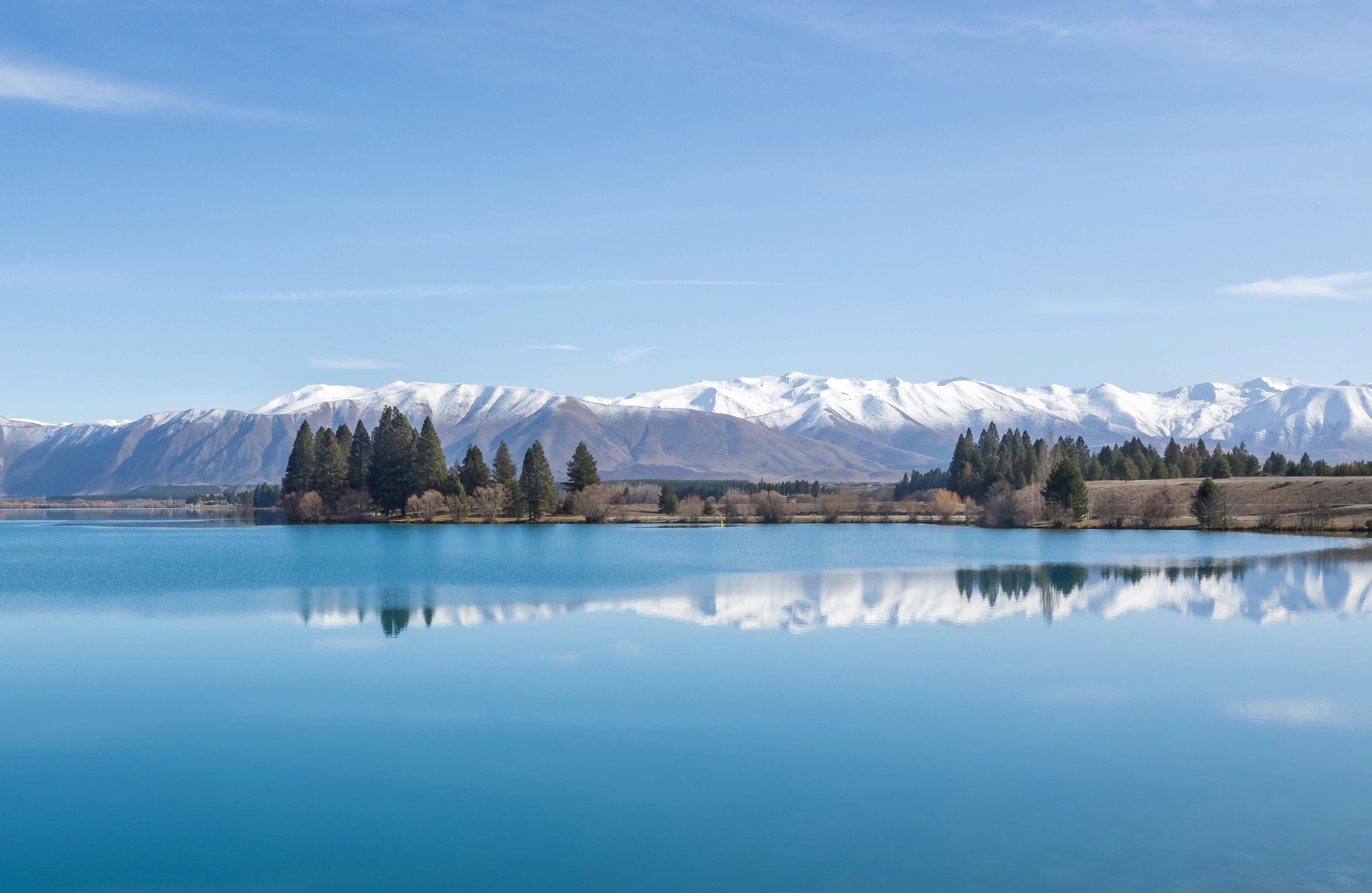 Glacial Lake Mirage: Snow‑capped Ridge Reflected in Quiet Waters