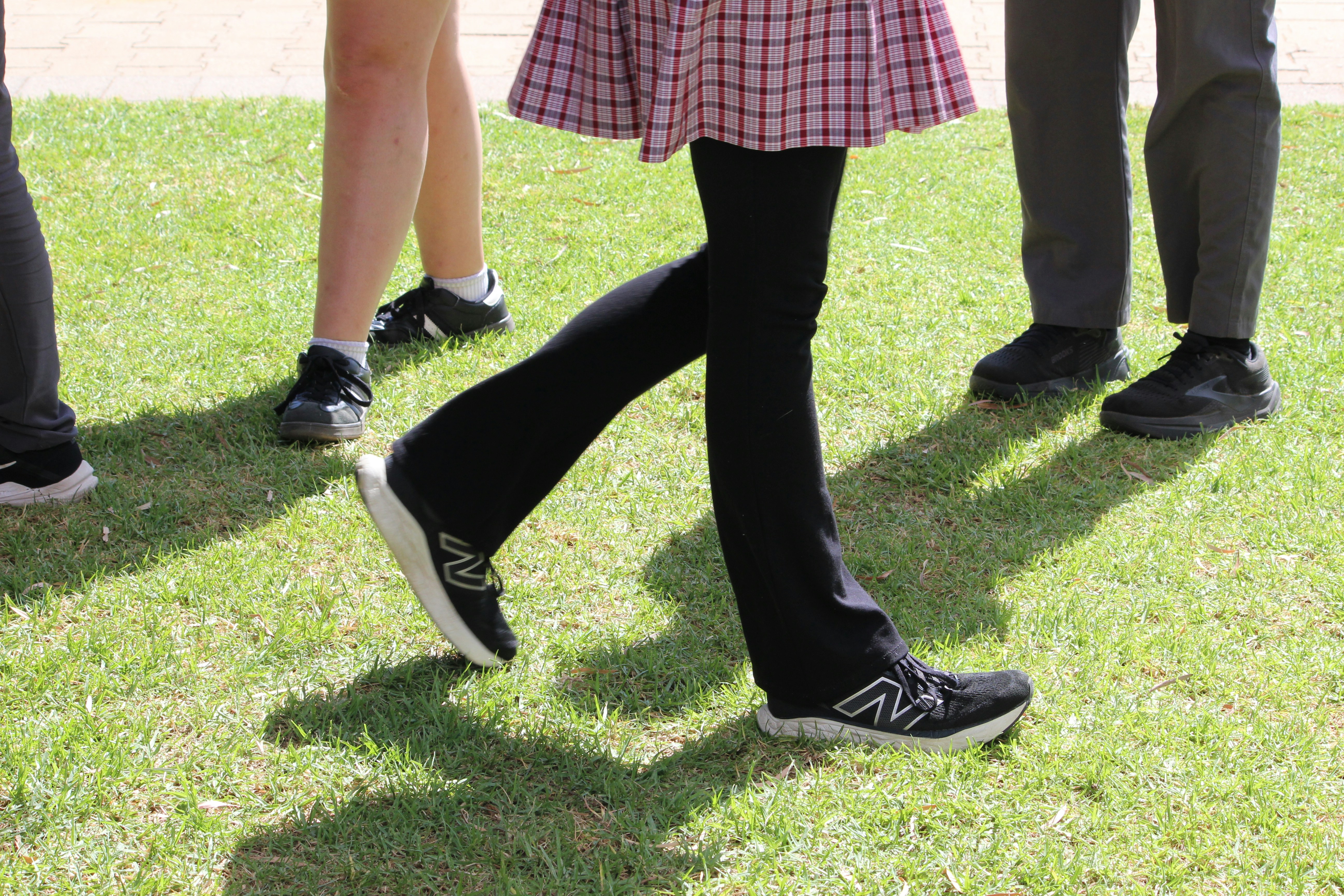 Stride in the Spotlight: Footwear and Movement on a Sunlit Lawn