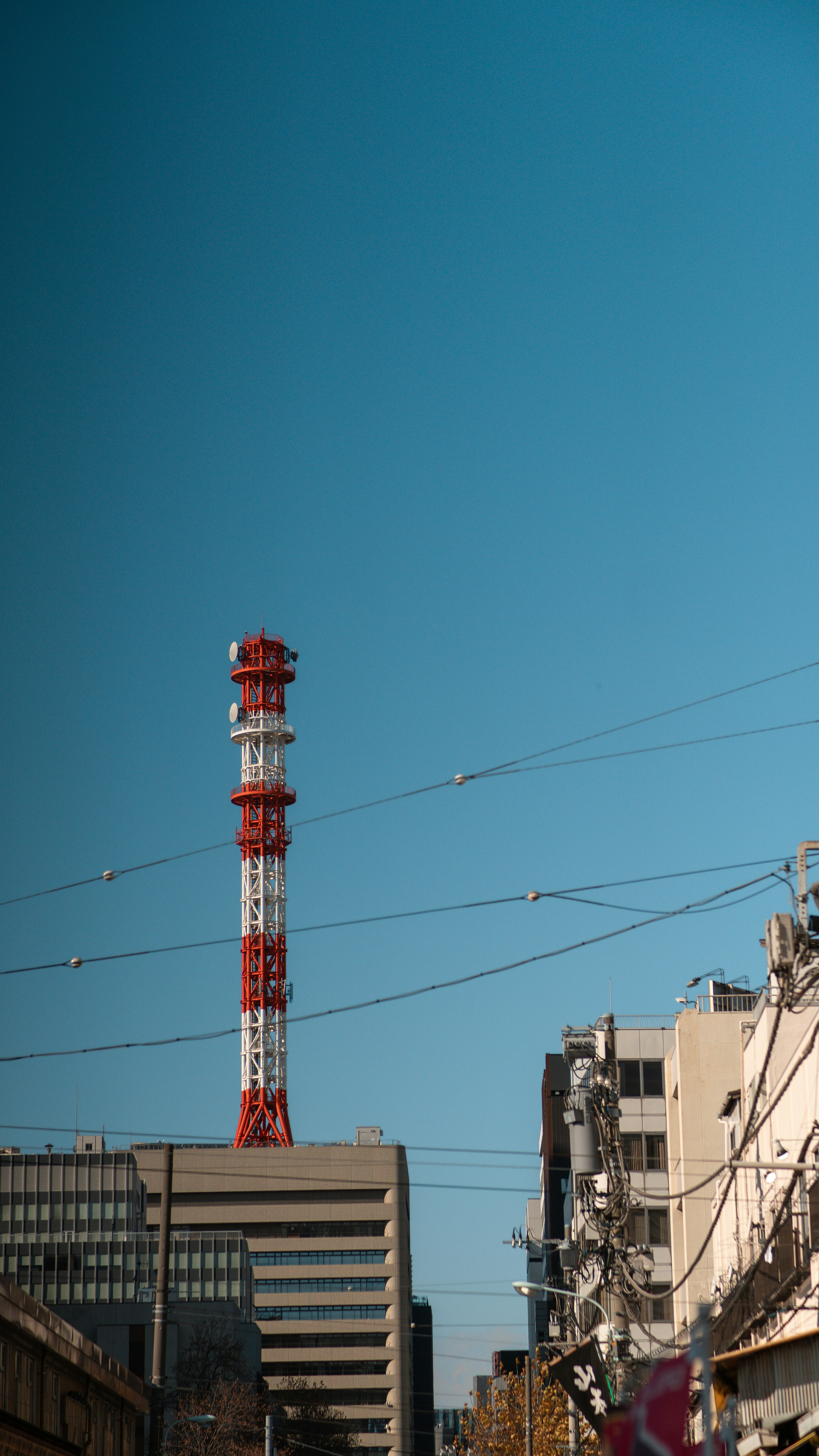 Urban Signal: A Red-and-White Tower Reaches for a Clear Sky