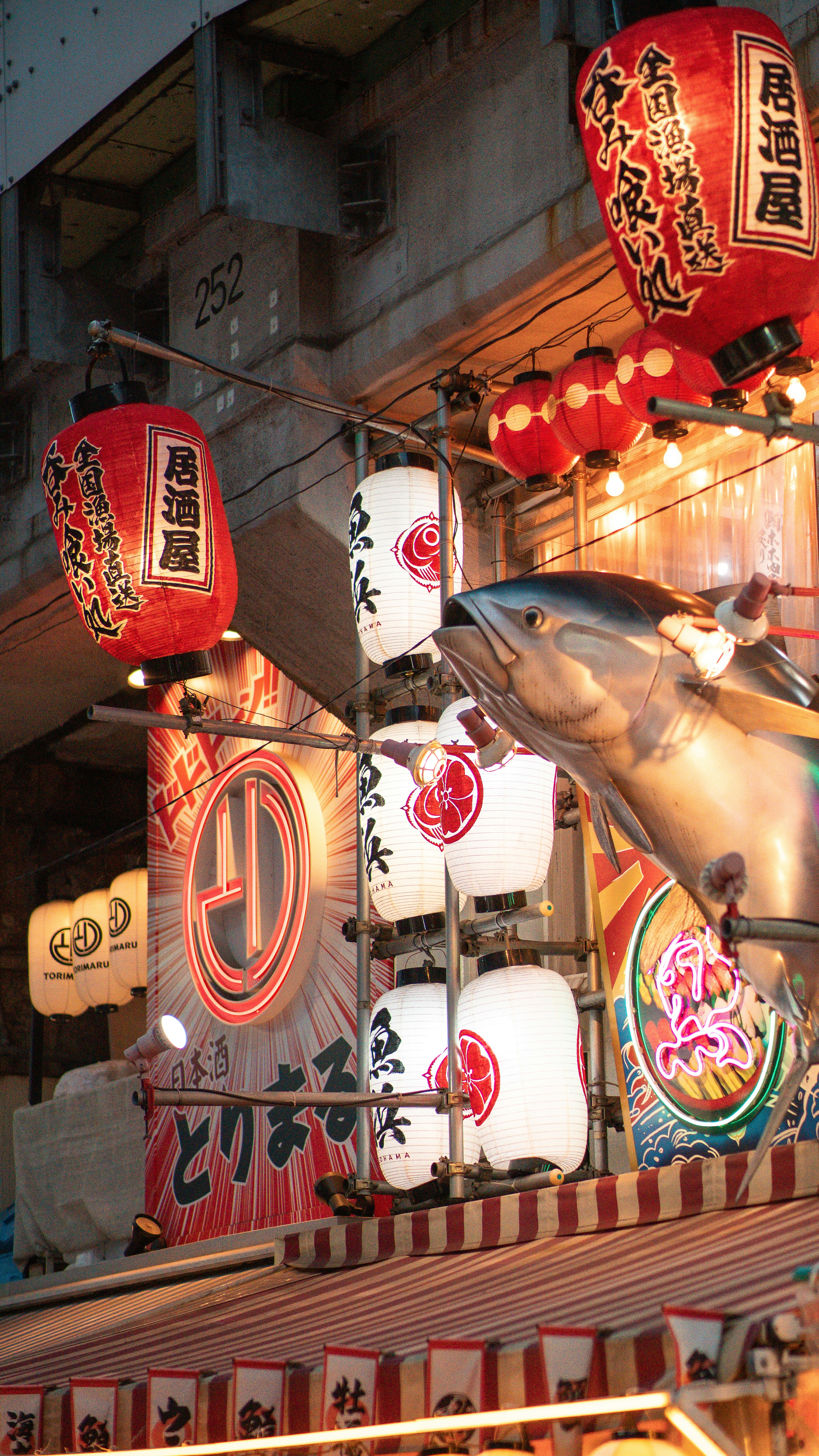 Lantern Glow Over Neon Street: A Fish Mascot Anchors the Night Market