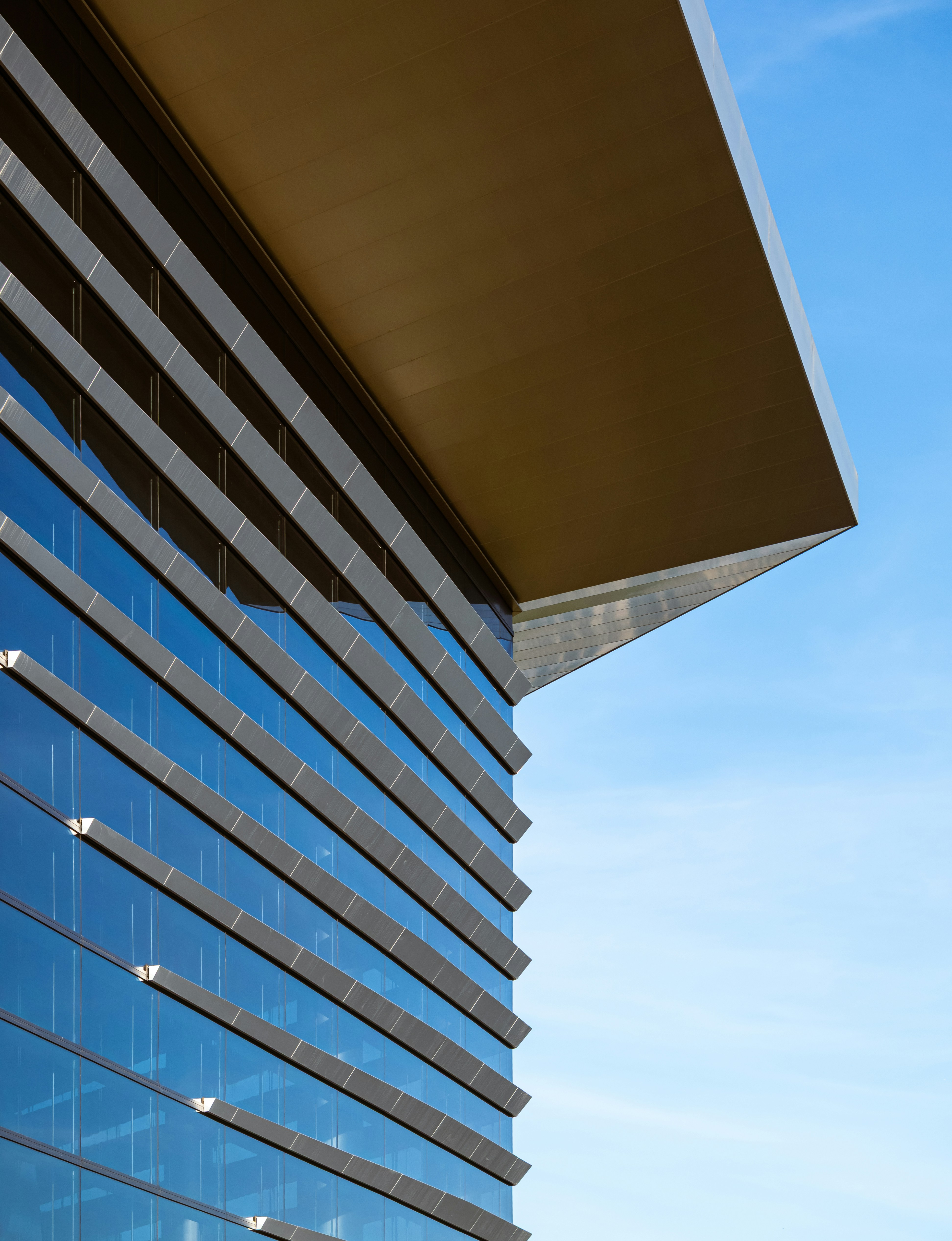 Overhanging Wing: The Diamond-Blue Facade Against a Clear Sky