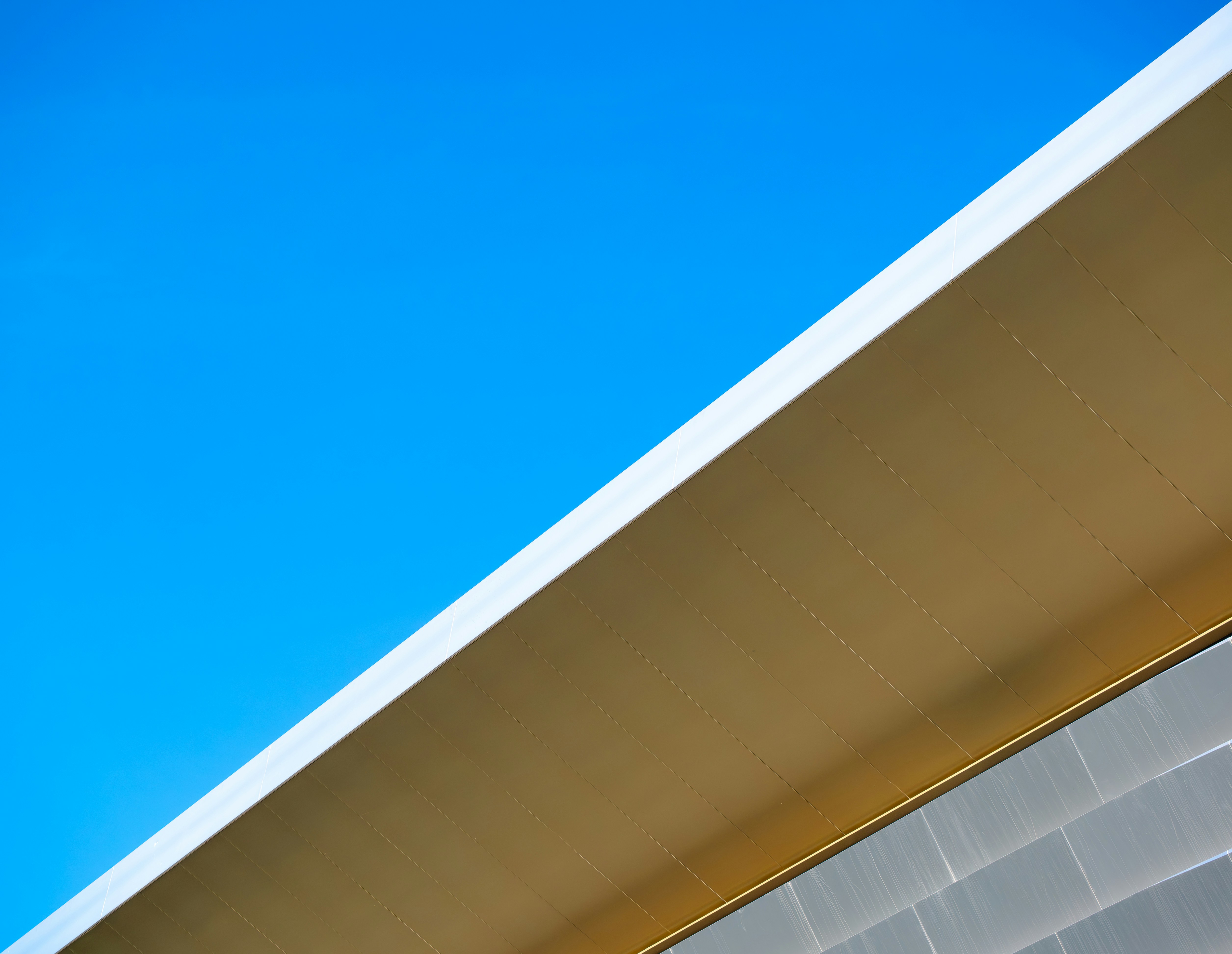 Diagonal Edge and Sky: Minimalist Architecture Under a Crisp Blue Canvas