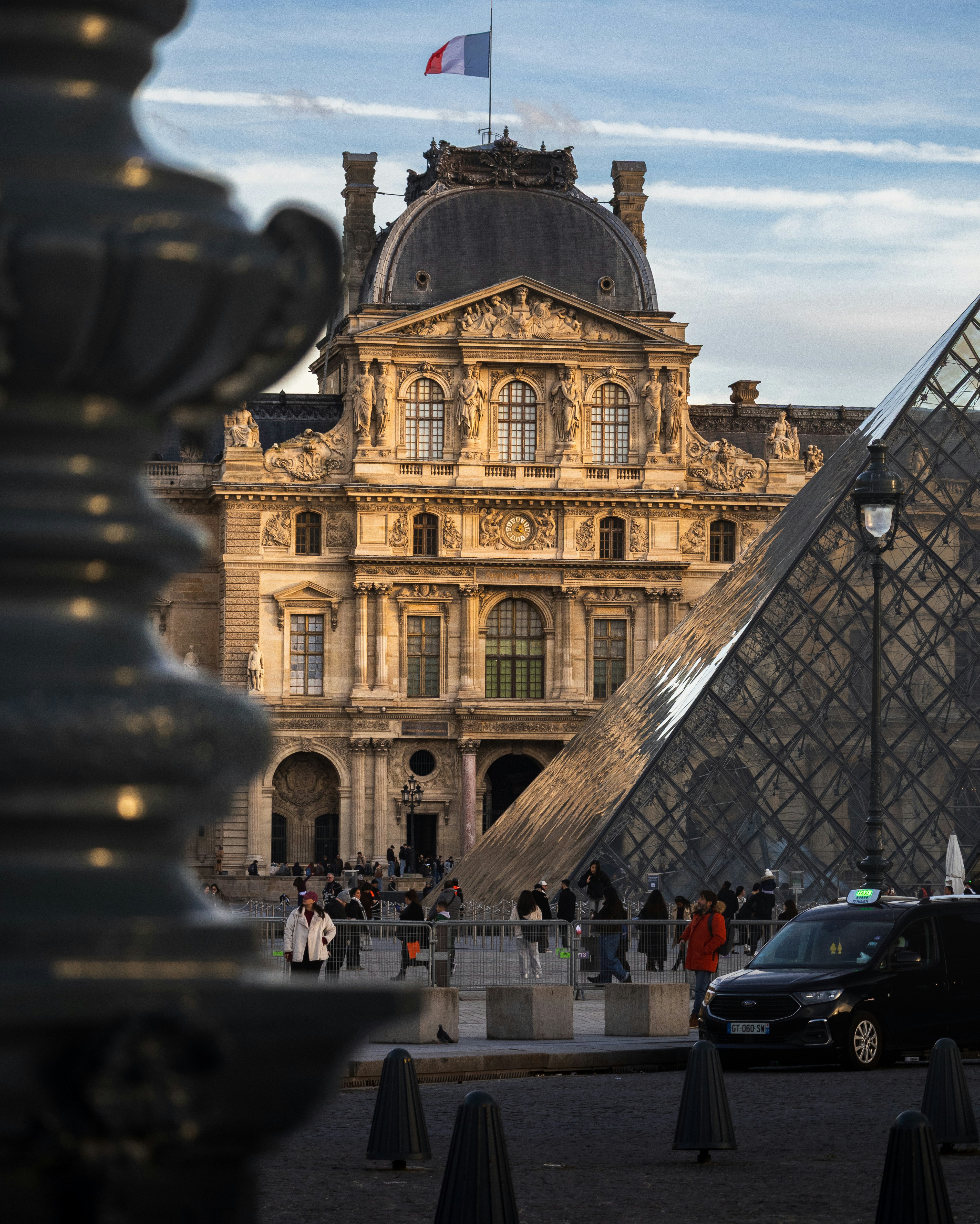 Sunlit Louvre Facade Framed by Glass Pyramid Edges