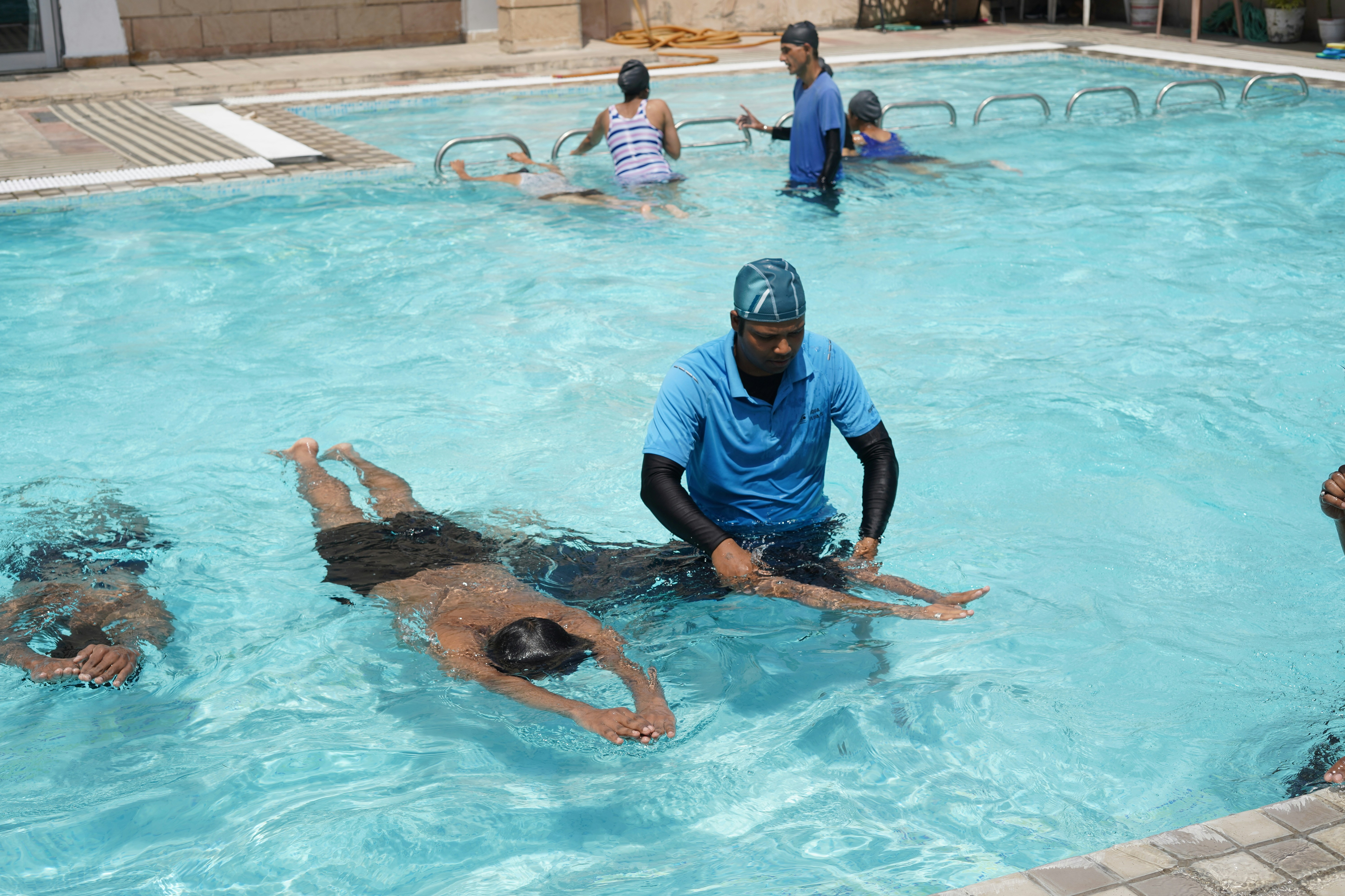 Guided Swim: A Lifeguard Demonstration in a Sunlit Pool