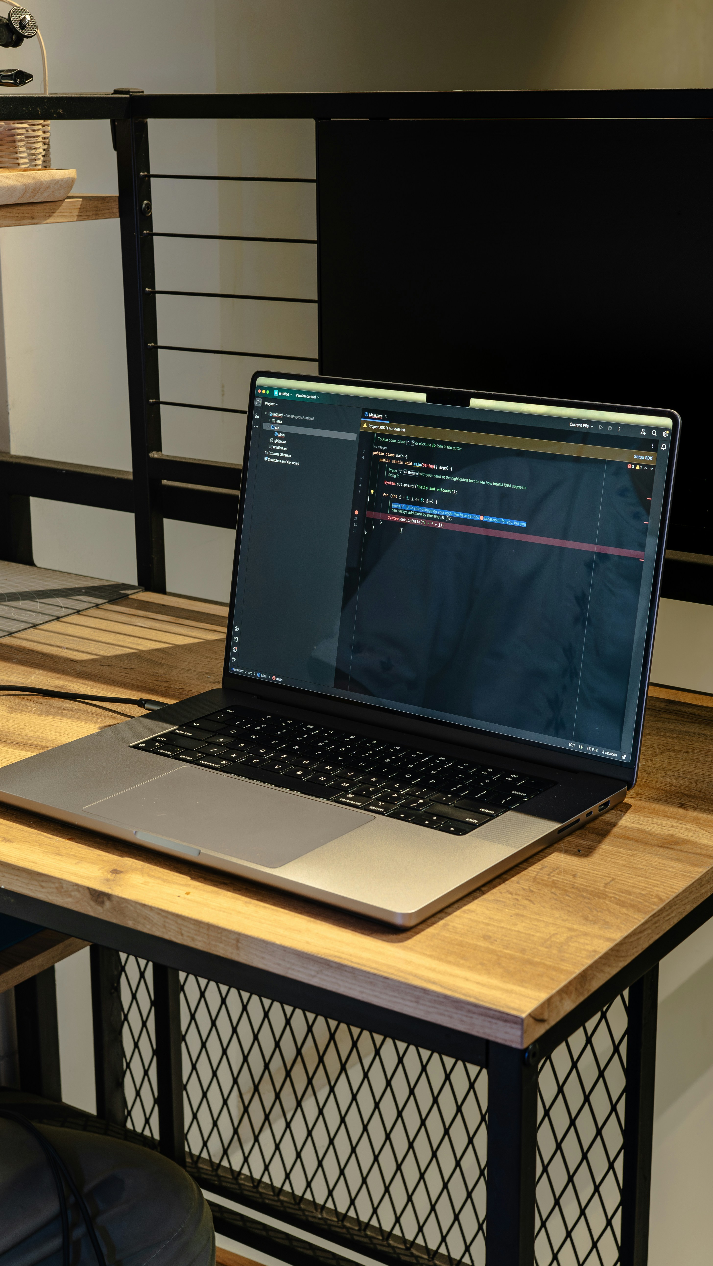 Code Workspace: Laptop on a Wooden Desk in a Studio Corner
