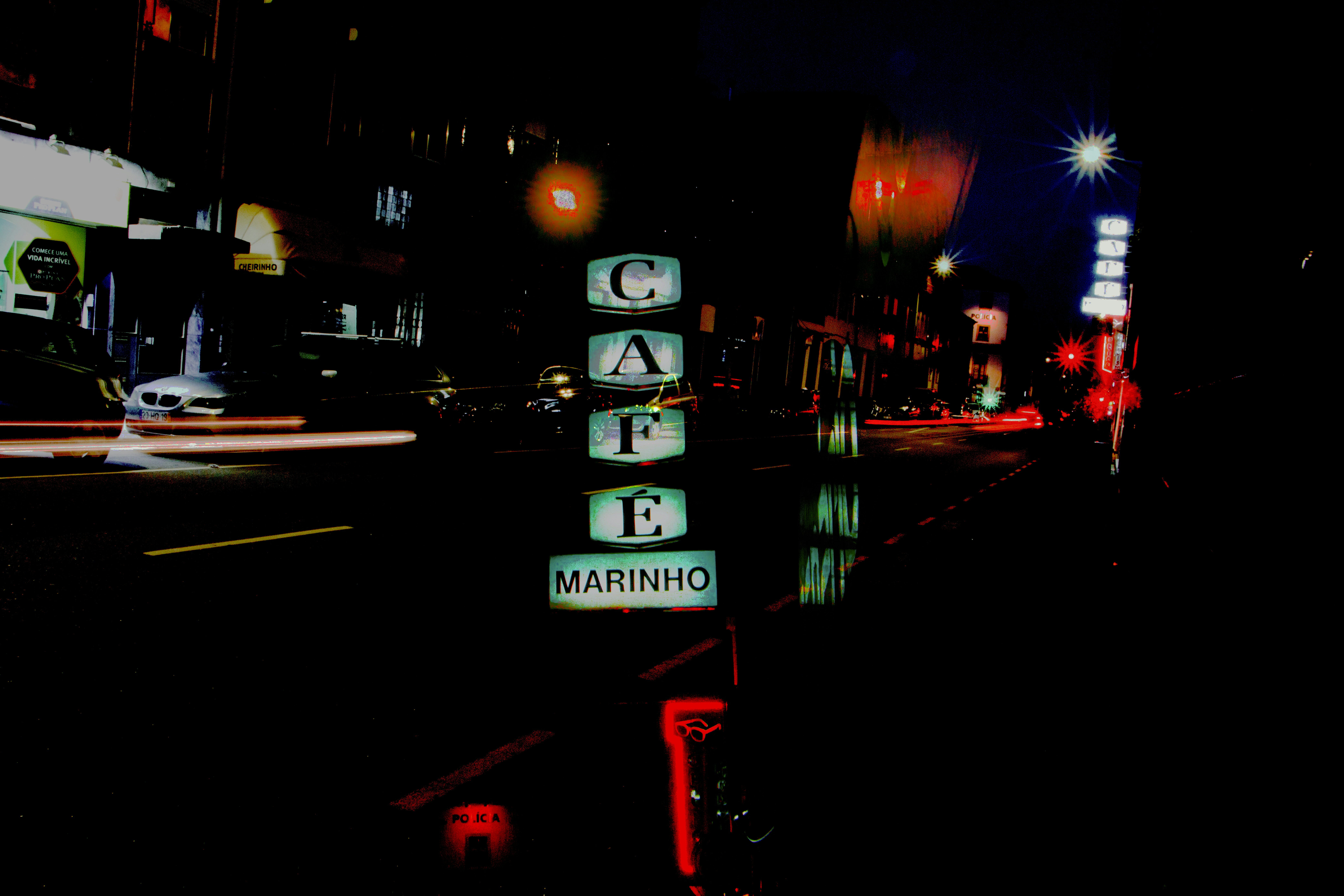 Neon Café Sign Reflections in a Rain-Slick Street