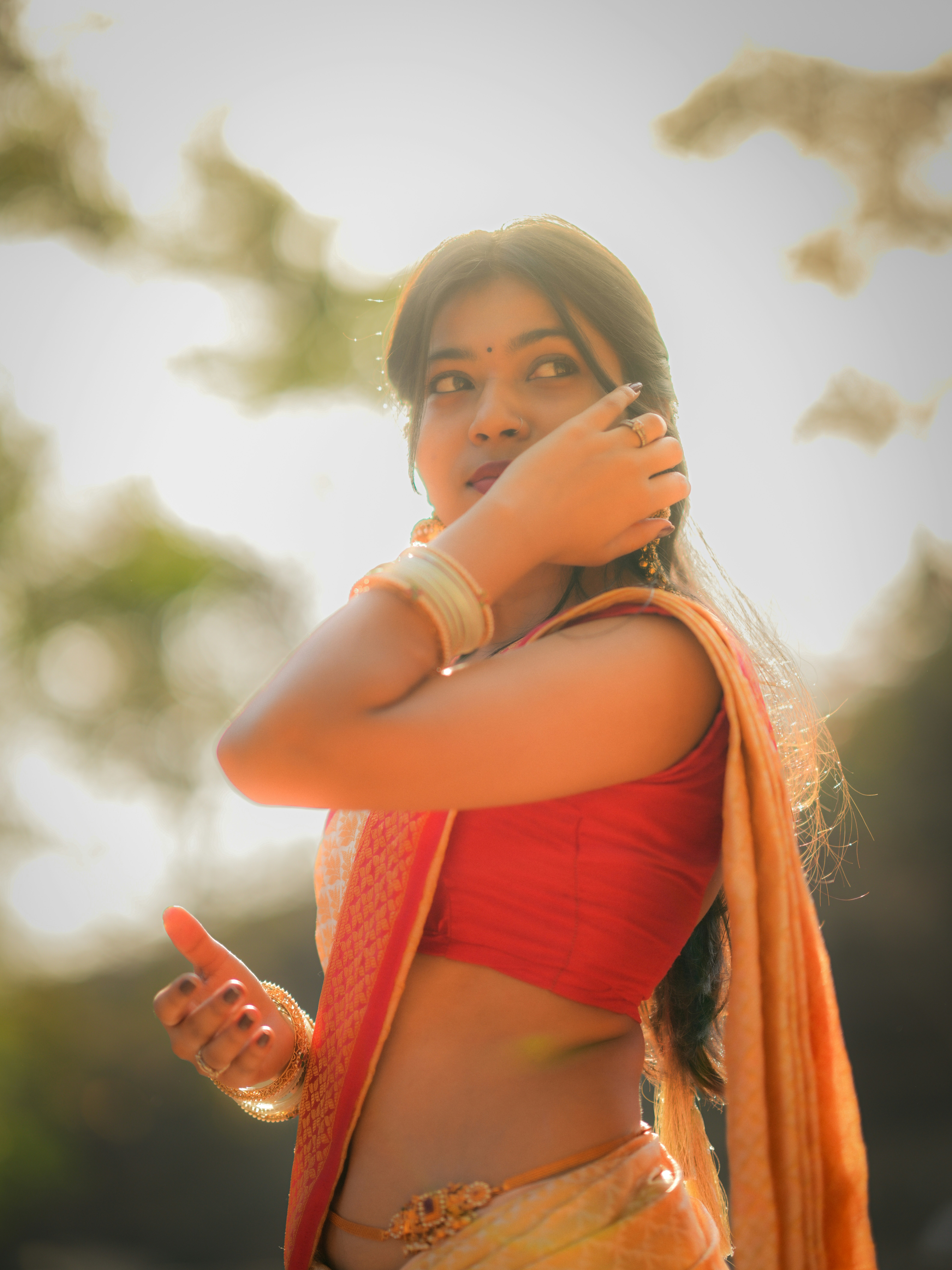 Sunlit Grace: A Mid-Exposure Stare with Draped Orange Salwar