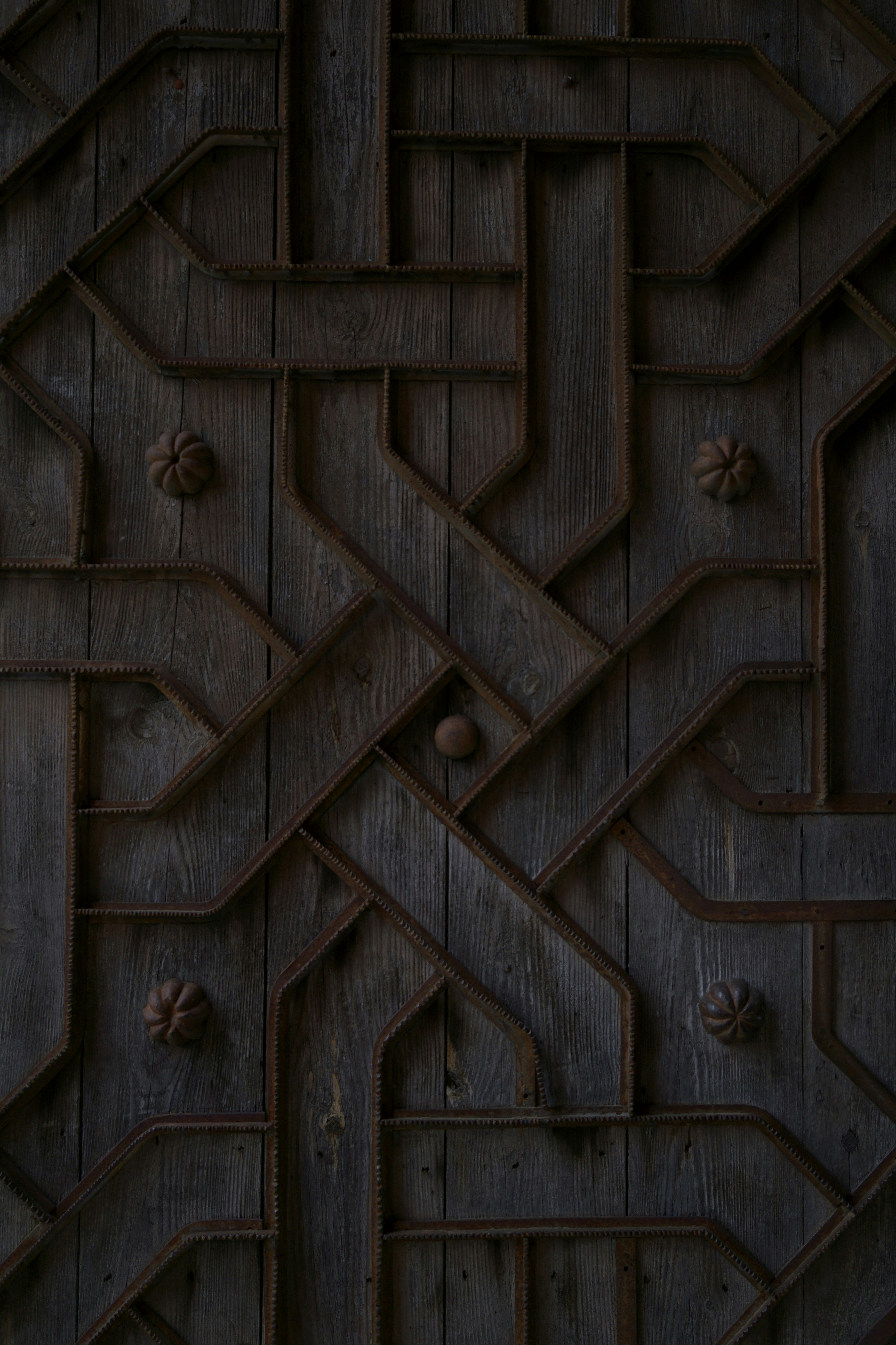 Intricate Ironwork on a Weathered Door: Geometric Texture in Shadow