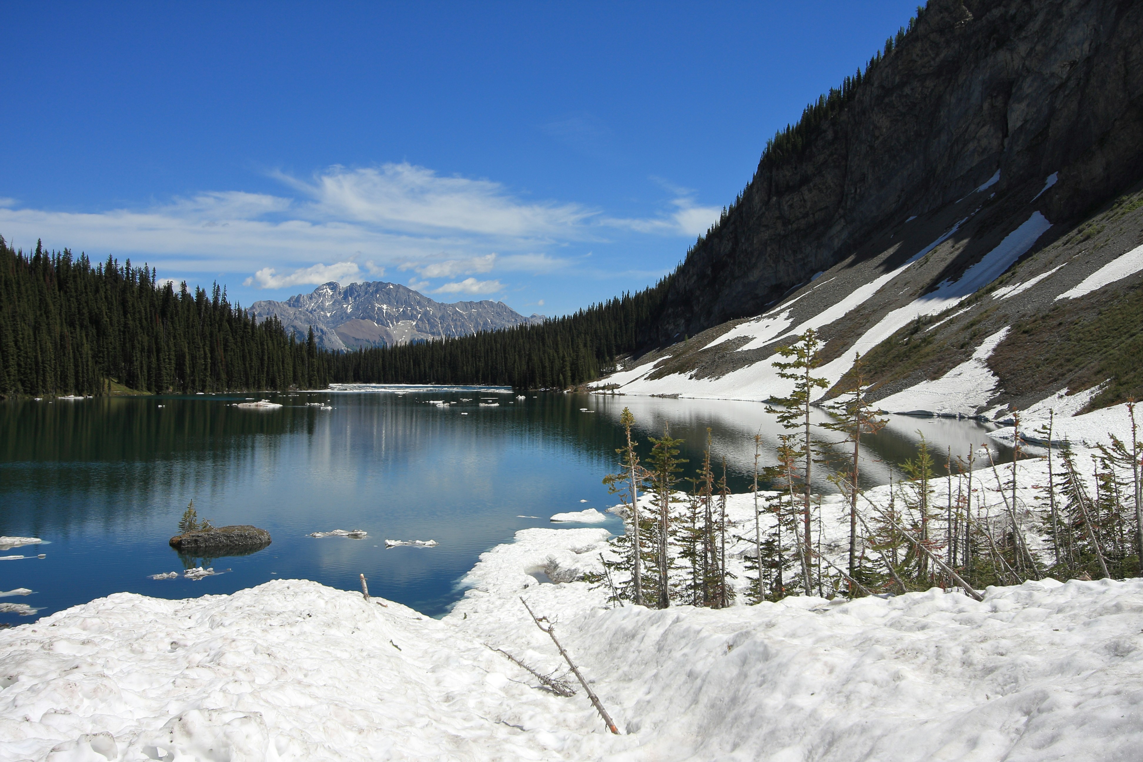 Snowbound Mirror: A Mountain Lake Reflects a Clear Sky